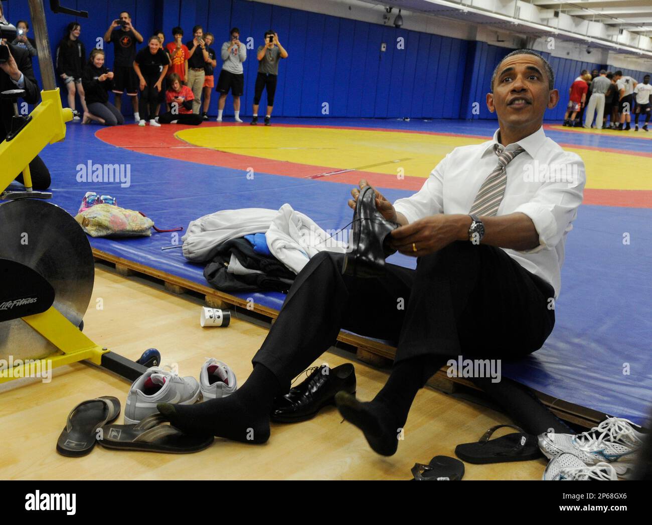 President Barack Obama puts on his shoes after removing them to walk on ...