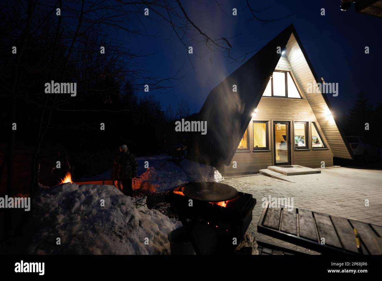 Wood fired barbecue against triangle country house at night Stock Photo ...