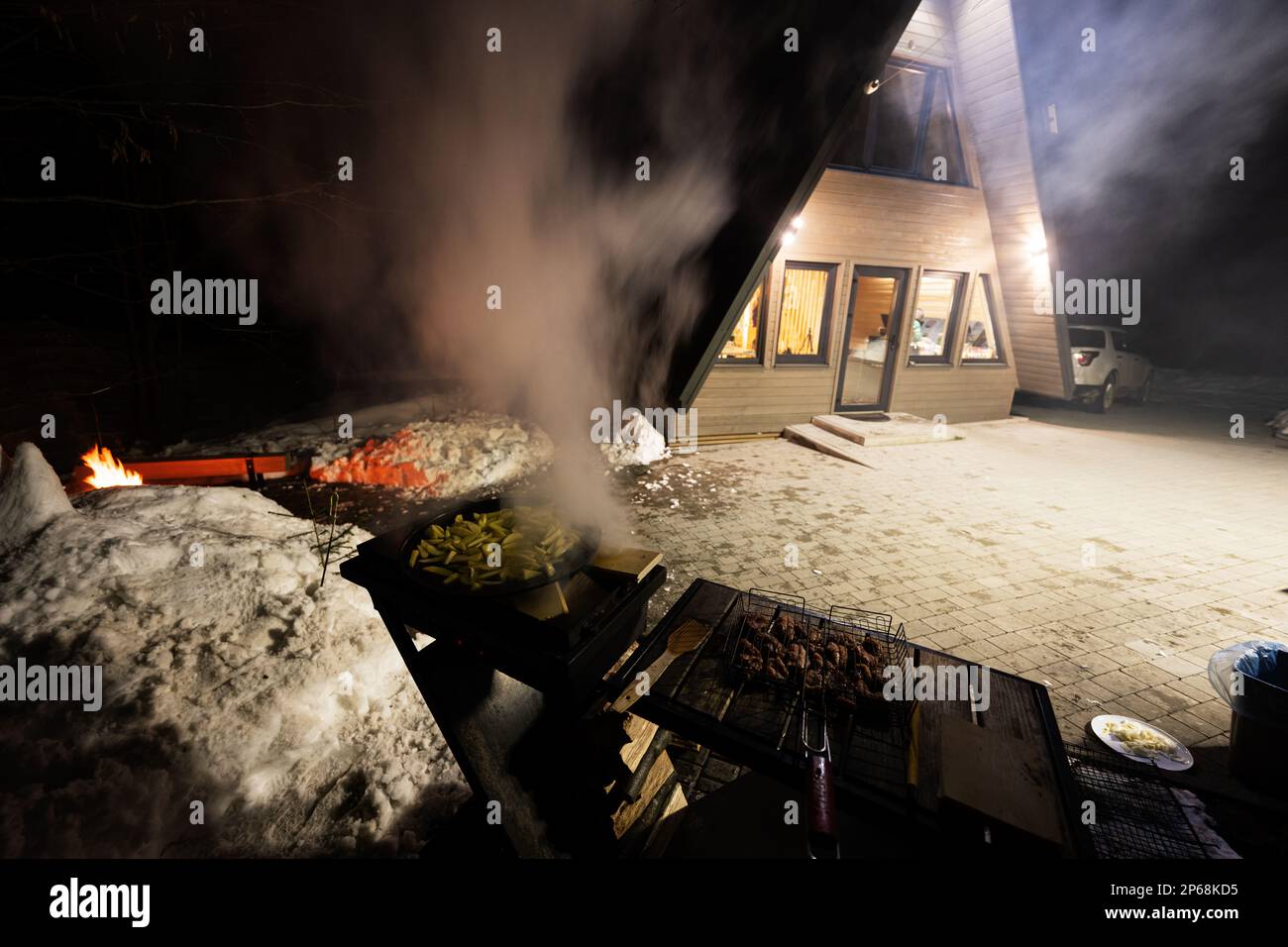 Wood fired barbecue against triangle country house at night Stock Photo ...