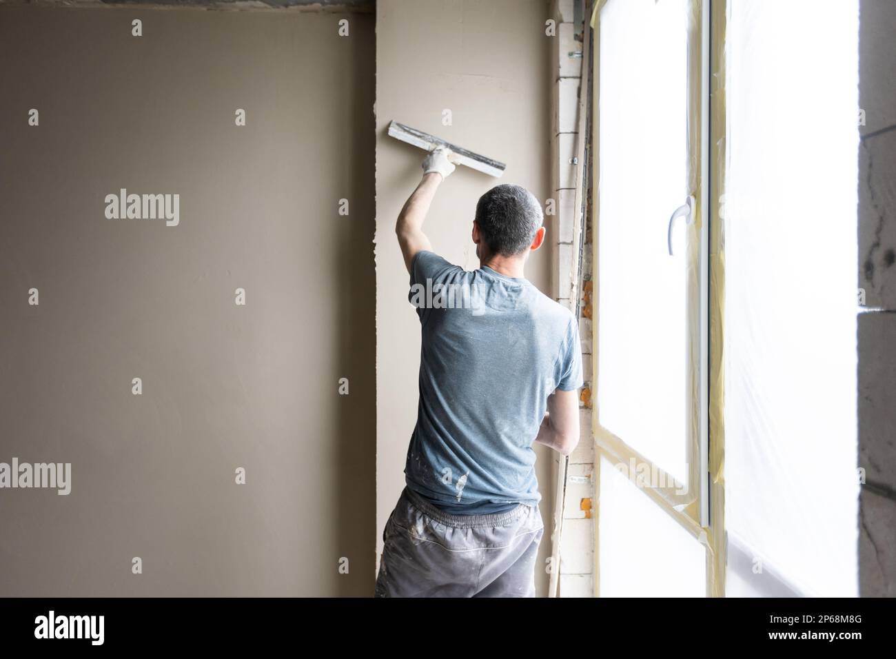 Construction worker wearing worker overall with wall plastering tools ...