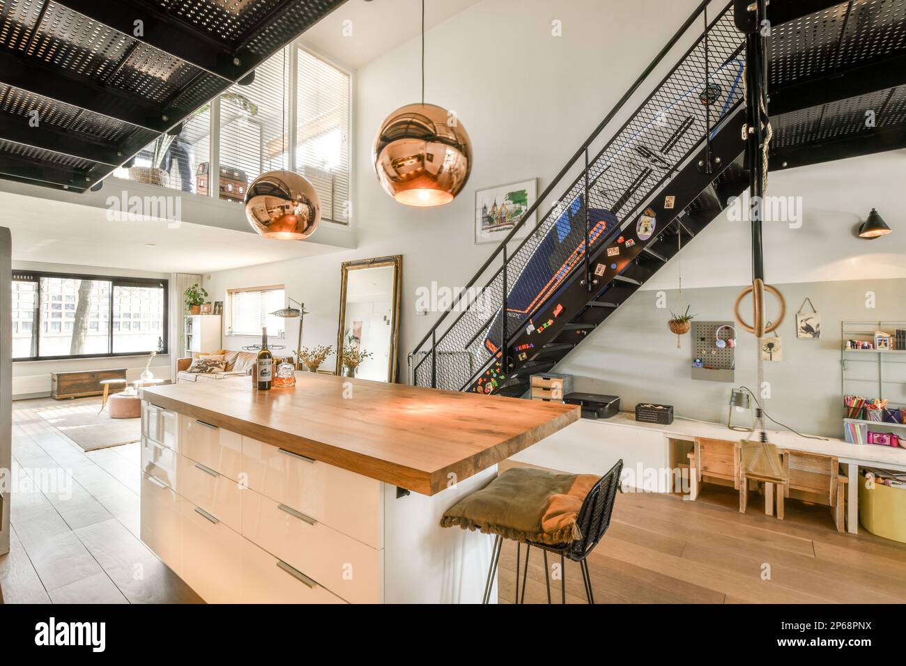a kitchen and living room in a loft style apartment with stairs leading up to the second floor ...