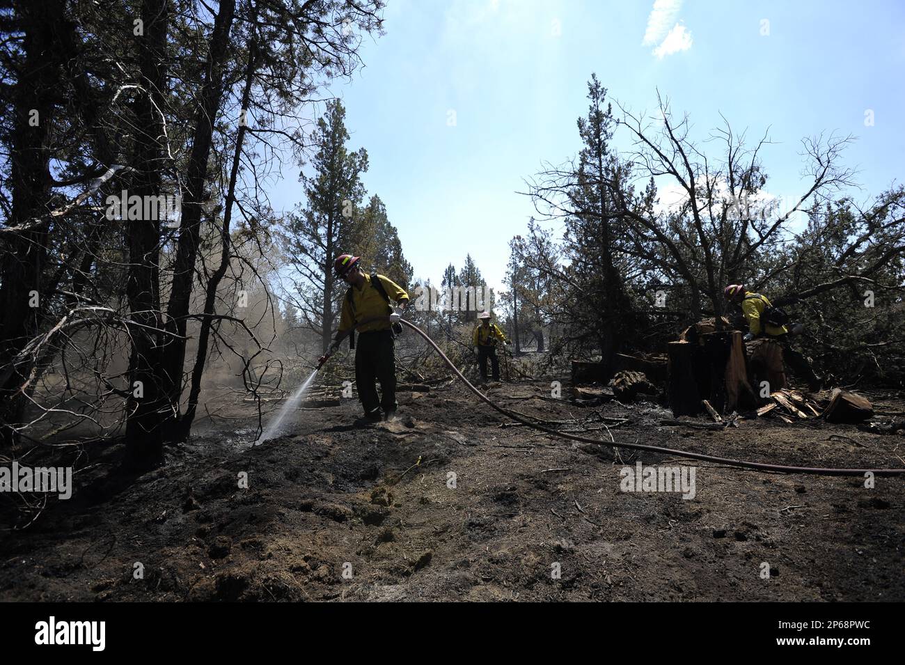 Firefighters work on extinguishing hotspots near the northern boundary ...