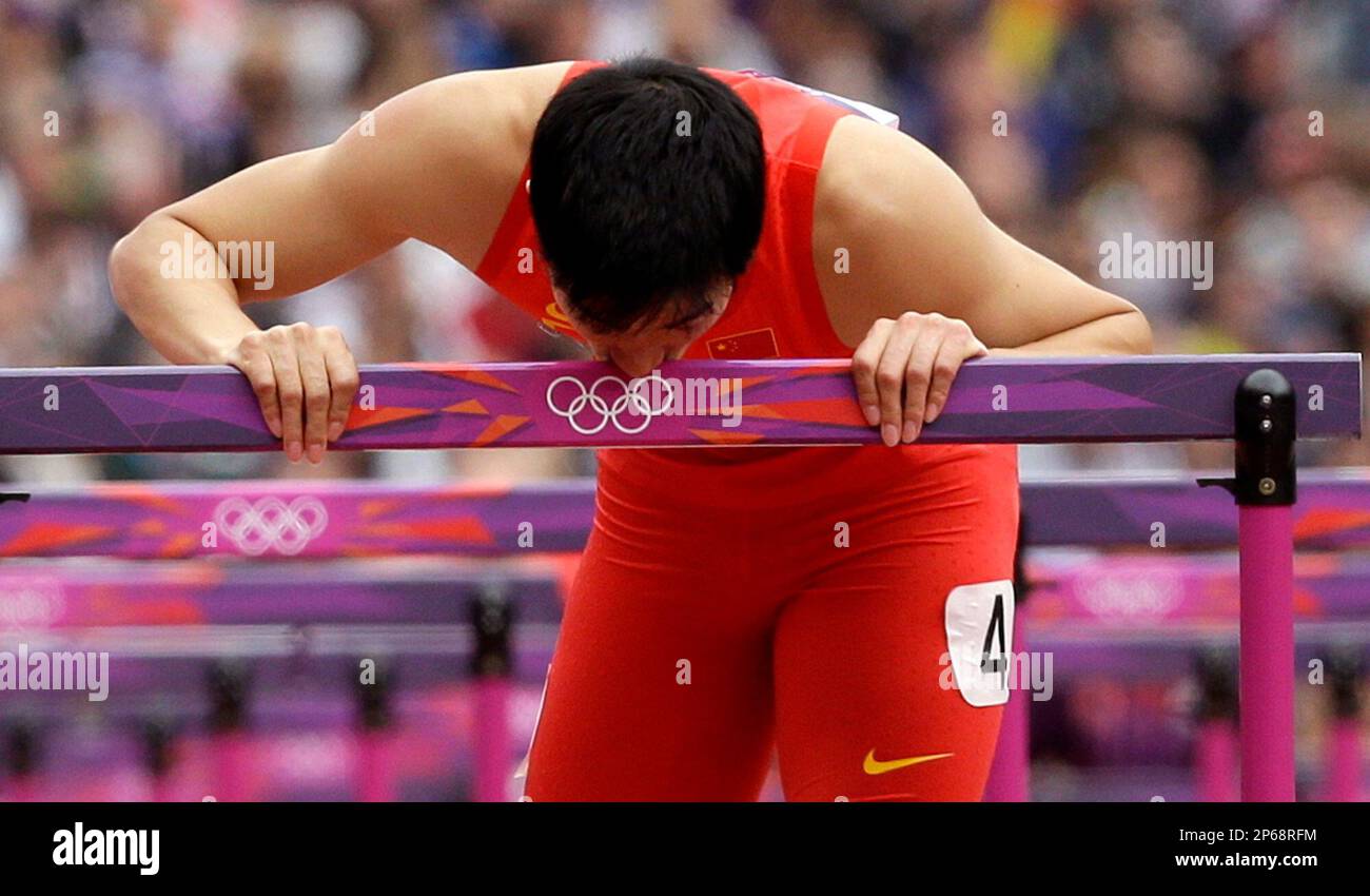 China's Liu Xiang kisses his hurdle after falling in a men's 110-meter ...