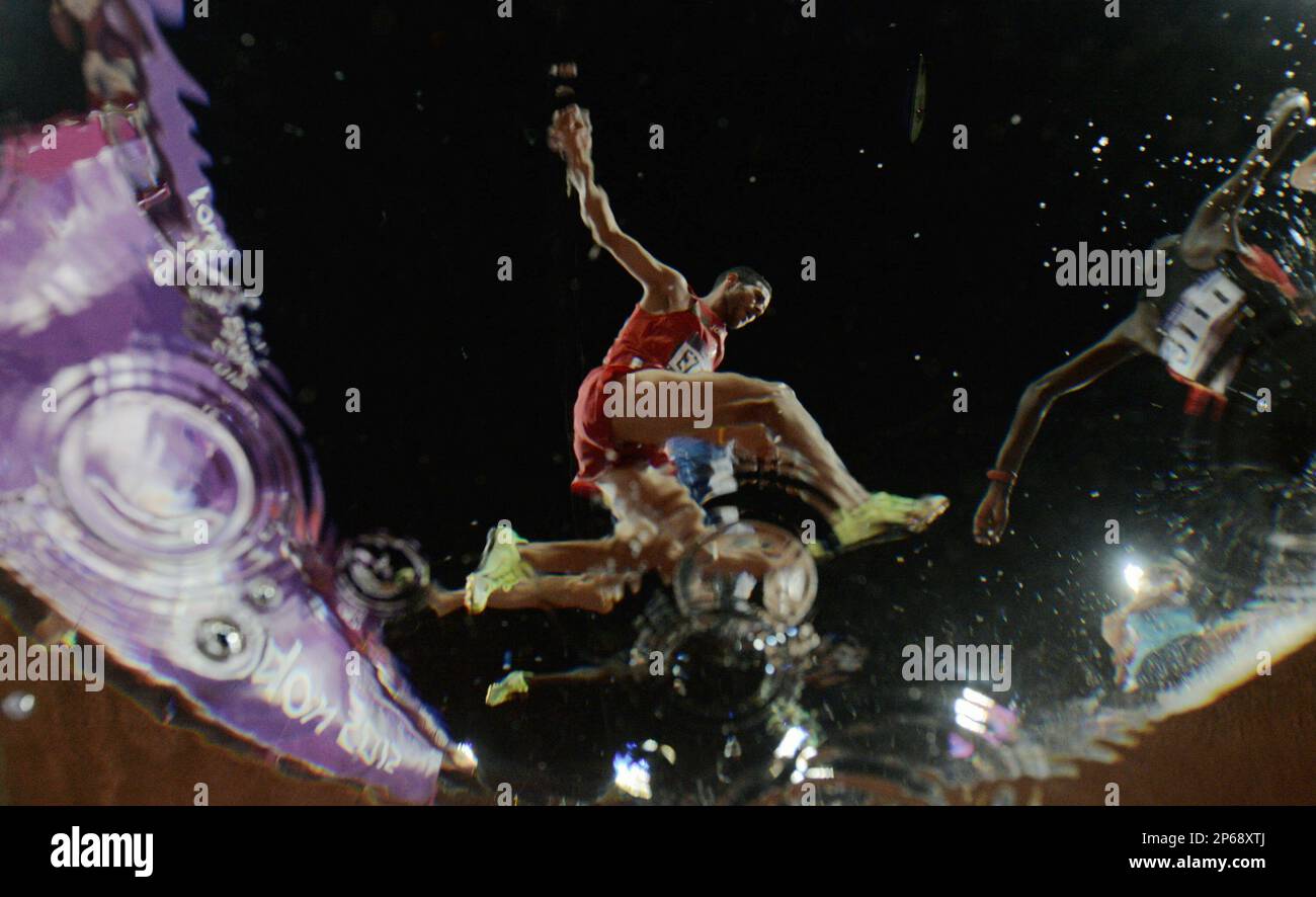 Athletes clear the water jump during the men's 3000-meter steeplechase ...