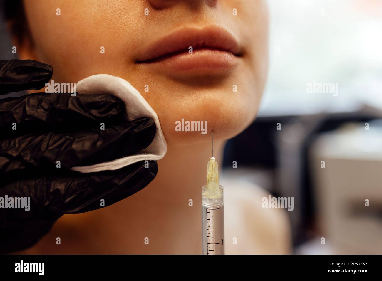 Beauty injections. Female cosmetologist in transparent gloves makes an ...