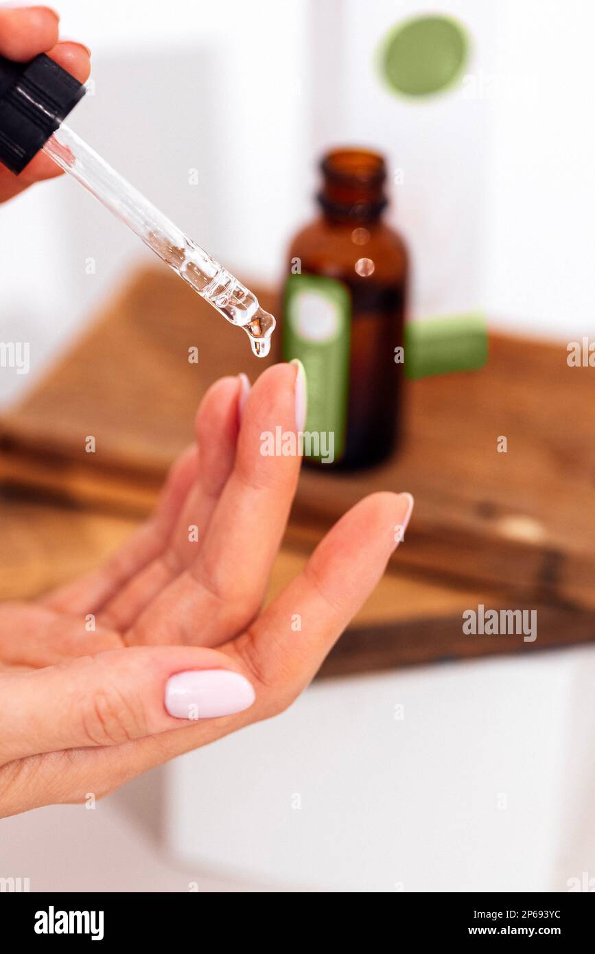 Extreme close up of womans hand and pipette. Transperent drop of ...
