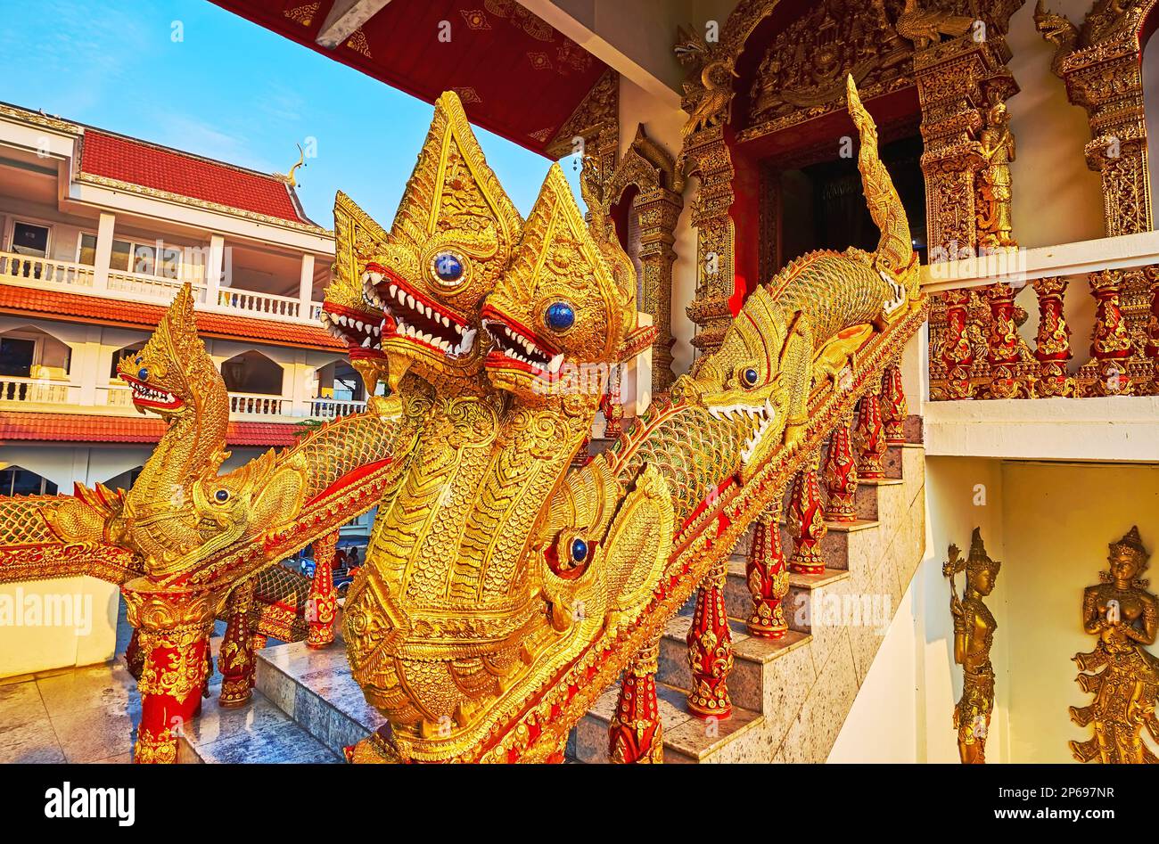 Ornate golden three-headed Naga serpent statues, appearing from the ...
