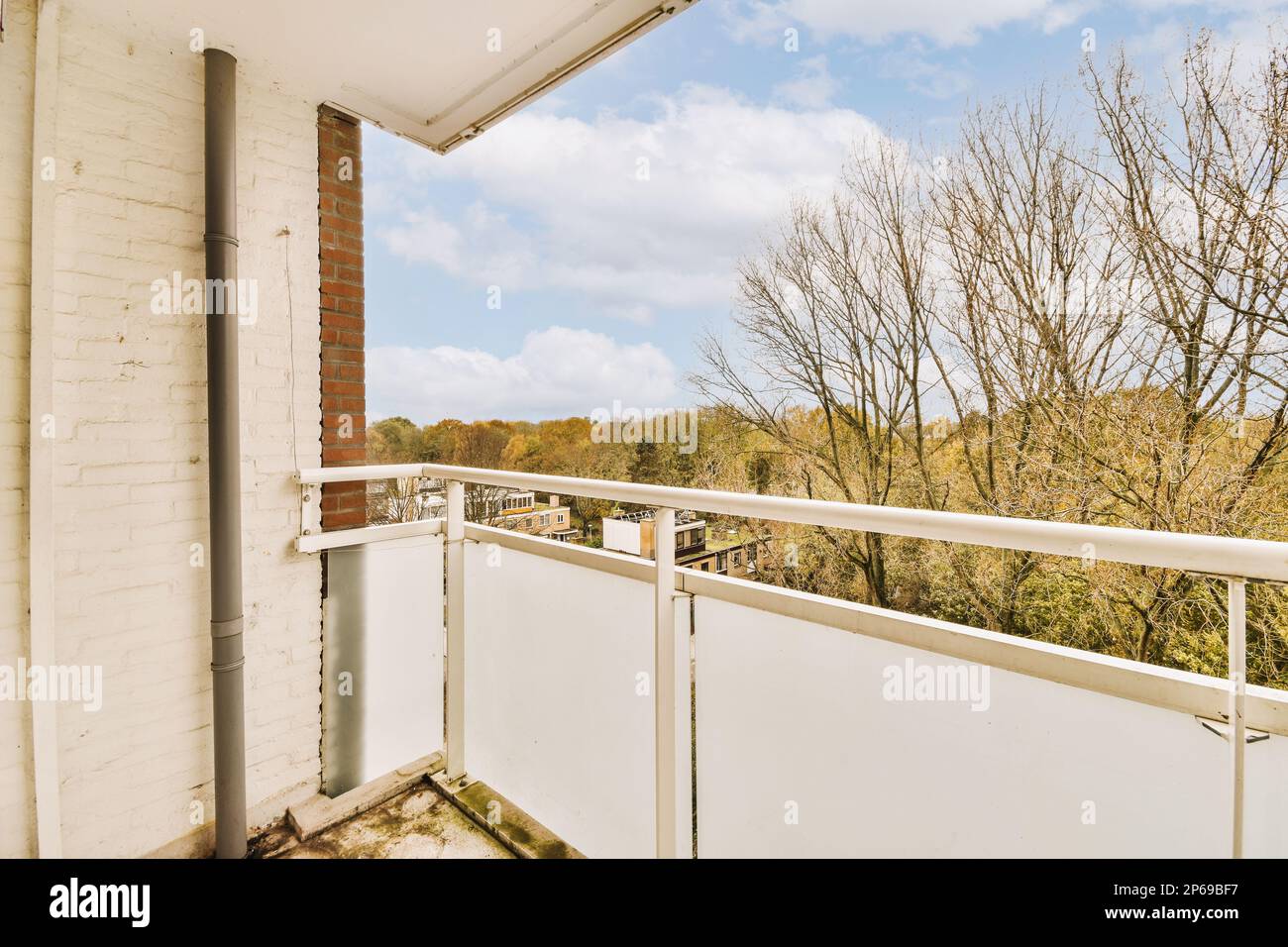 a balcony with white railings and trees in the background, as seen from ...
