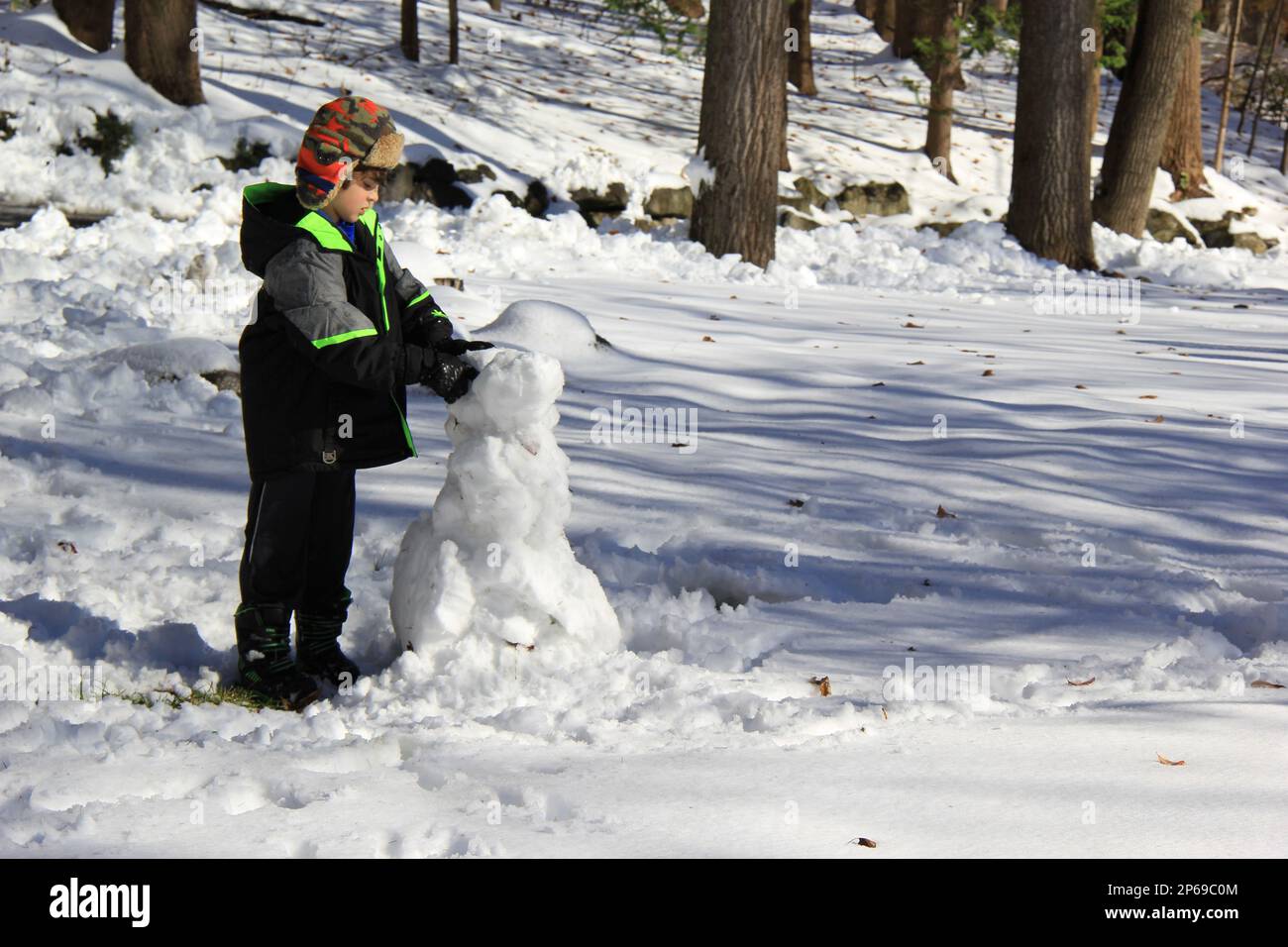 child building snowman Stock Photo - Alamy