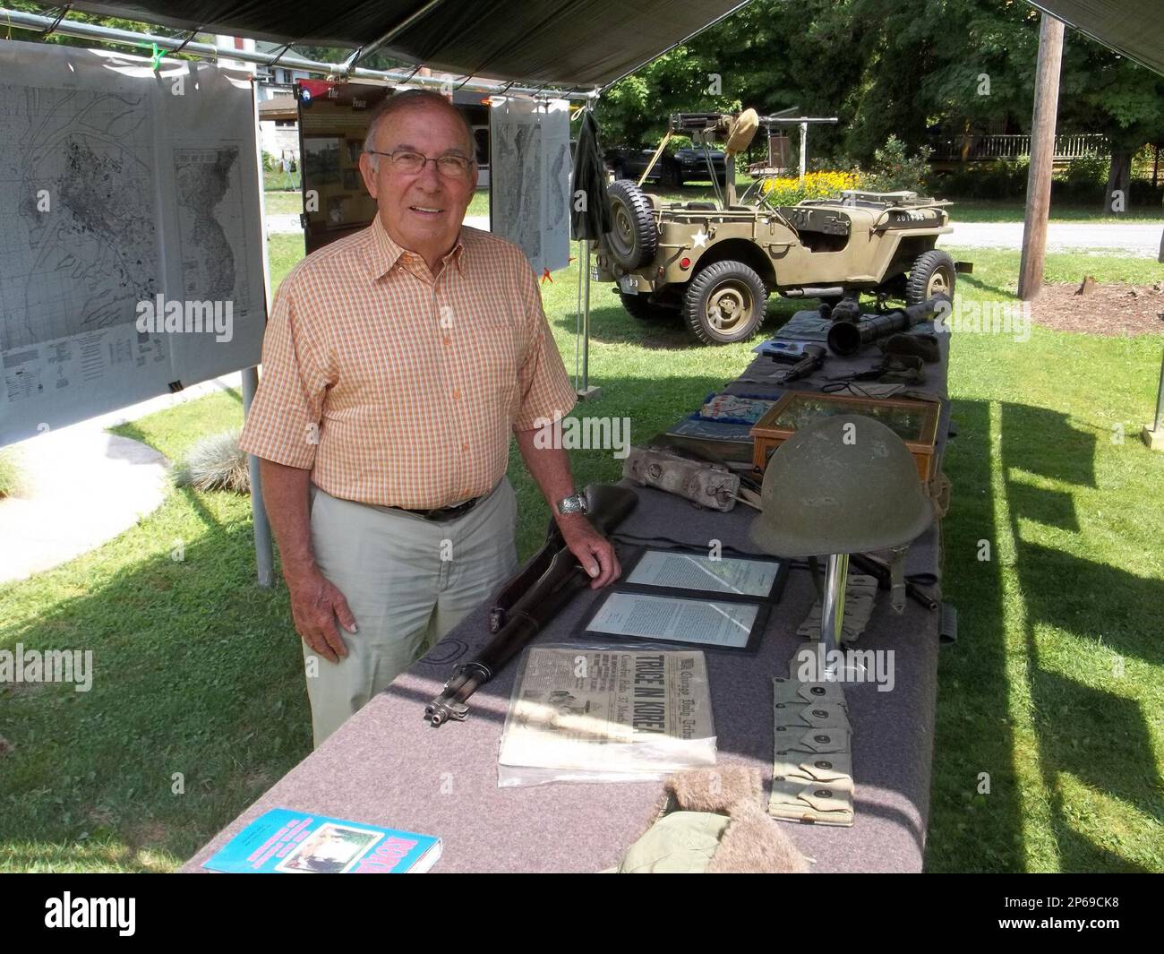 Bob Wetzel of Eagles Mere, Pa., stands by a display of military items ...