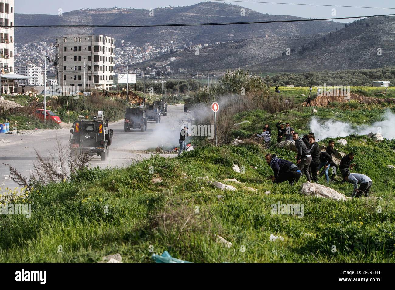 Palestinian youth throw stones at the Israeli army vehicles, in the ...