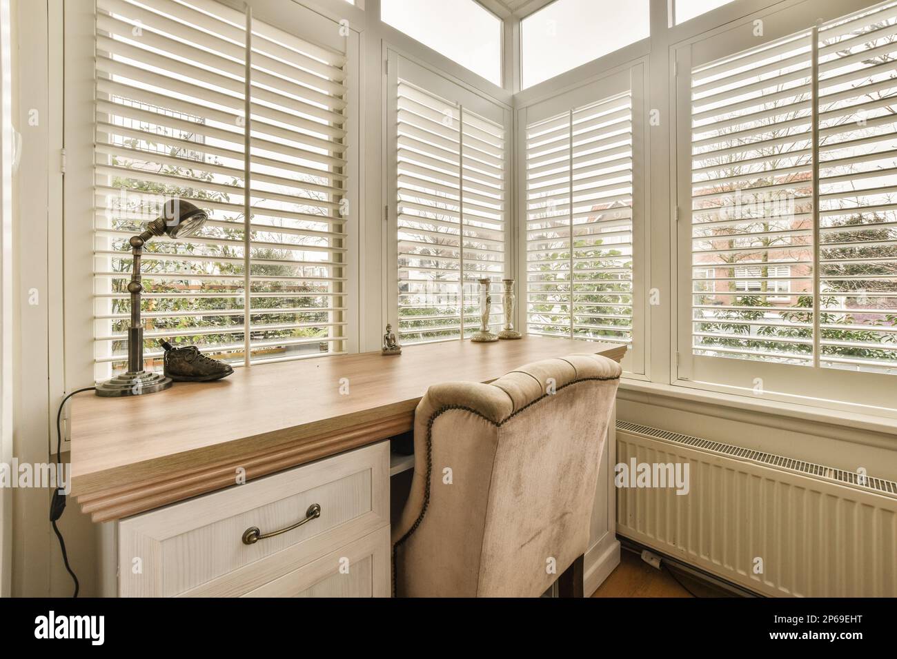 a window with shutters on the outside and an office desk in the middle ...