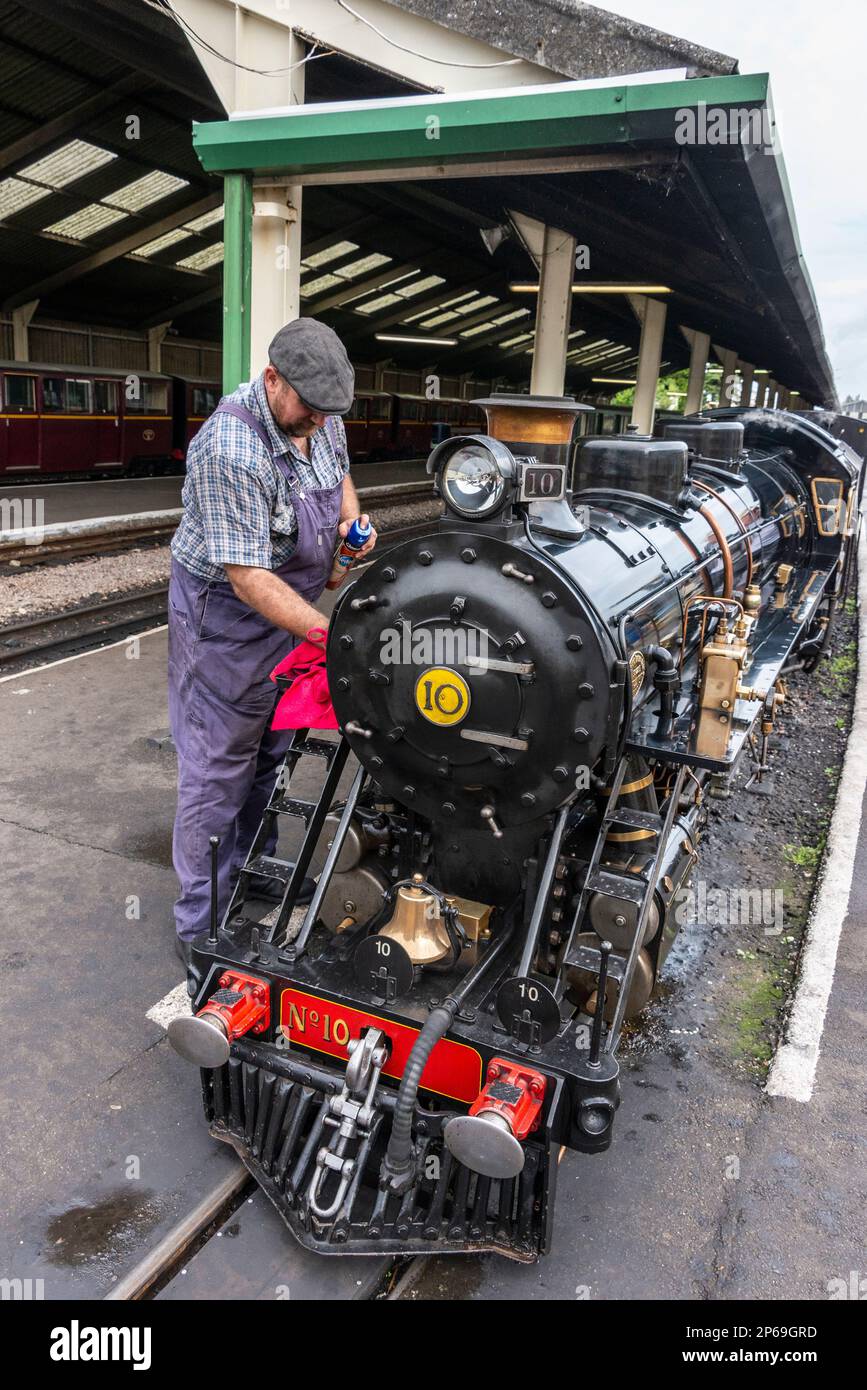 An engine driver gives a final clean before the small steam locomotive ...