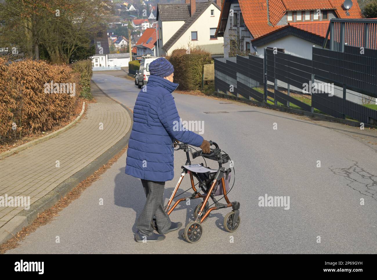 Alte gehbehinderte Frau mit Rollator überquert Straße - Model released ...