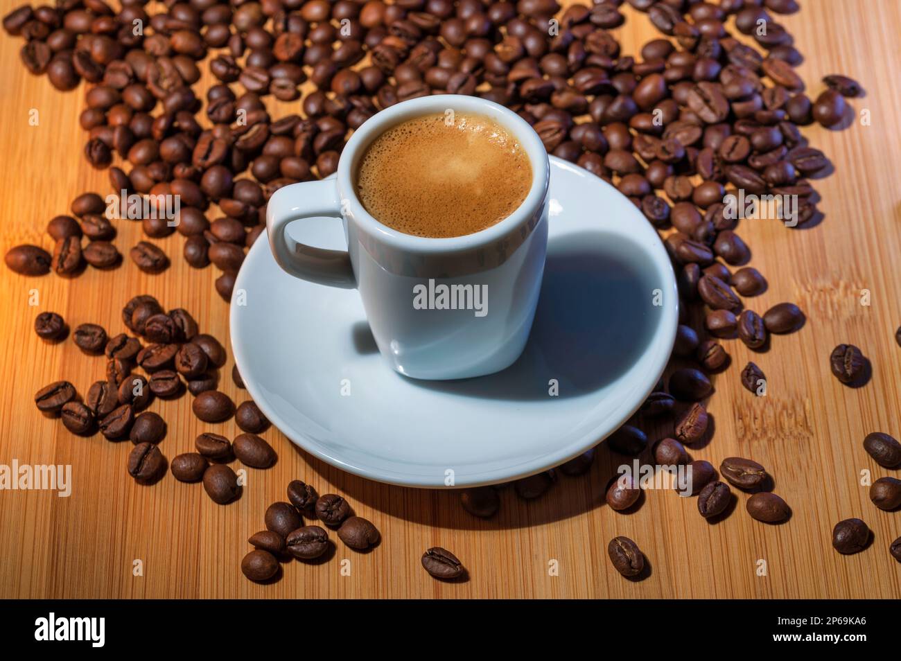coffee cup with mountain of coffee beans lying in wood Stock Photo - Alamy