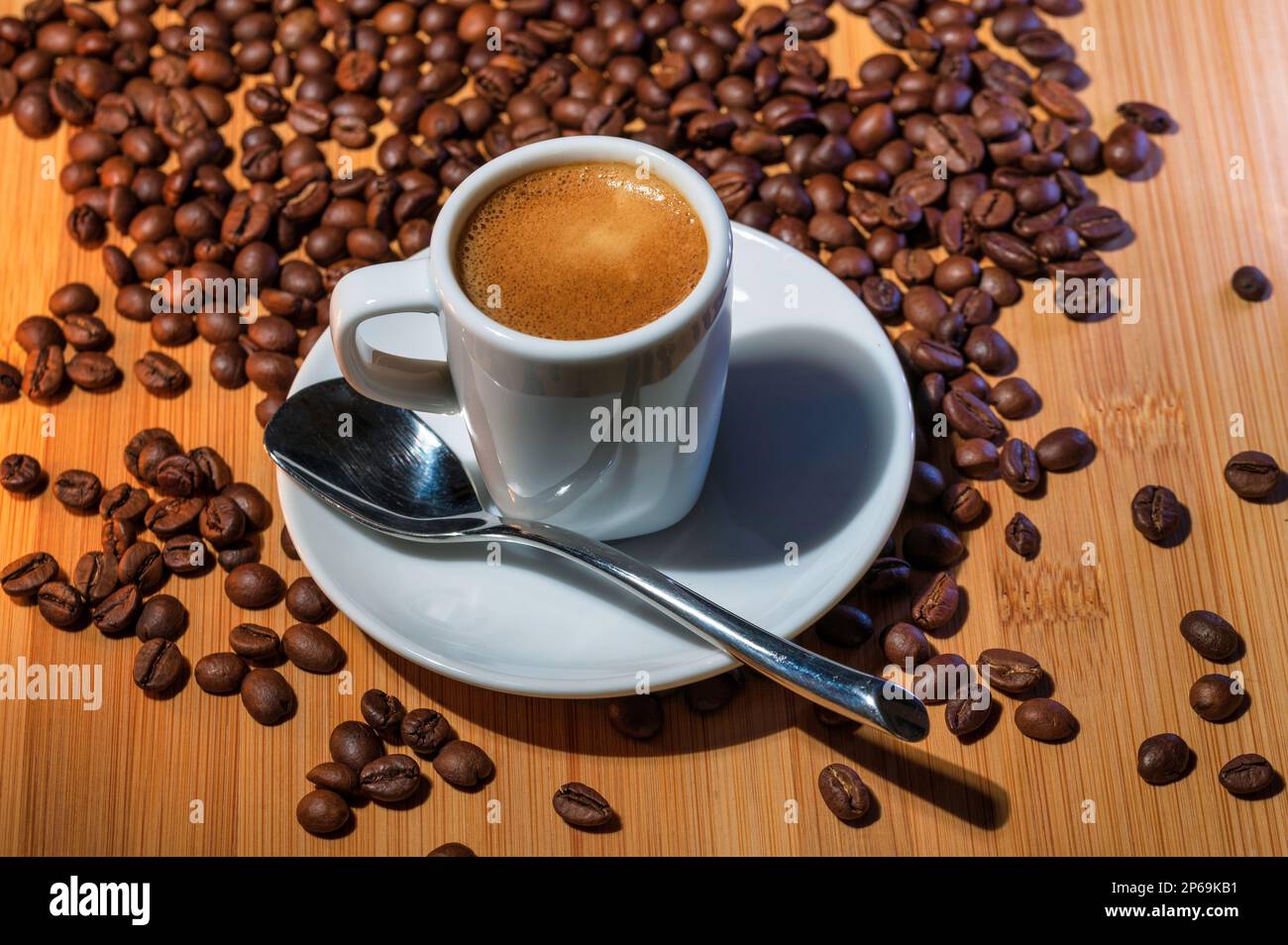 coffee cup with mountain of coffee beans lying in wood Stock Photo - Alamy