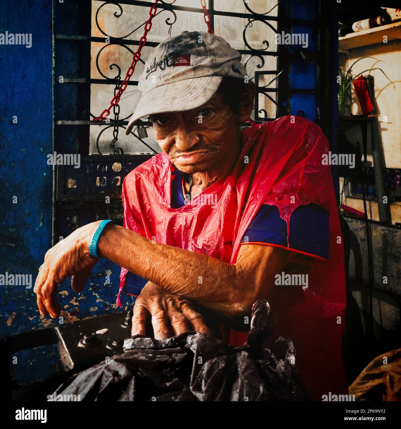 A Colombian worker wears a torn plastic sack to protect himself from a ...