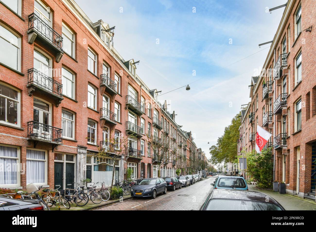 a city street with cars parked on both sides and buildings in the same ...