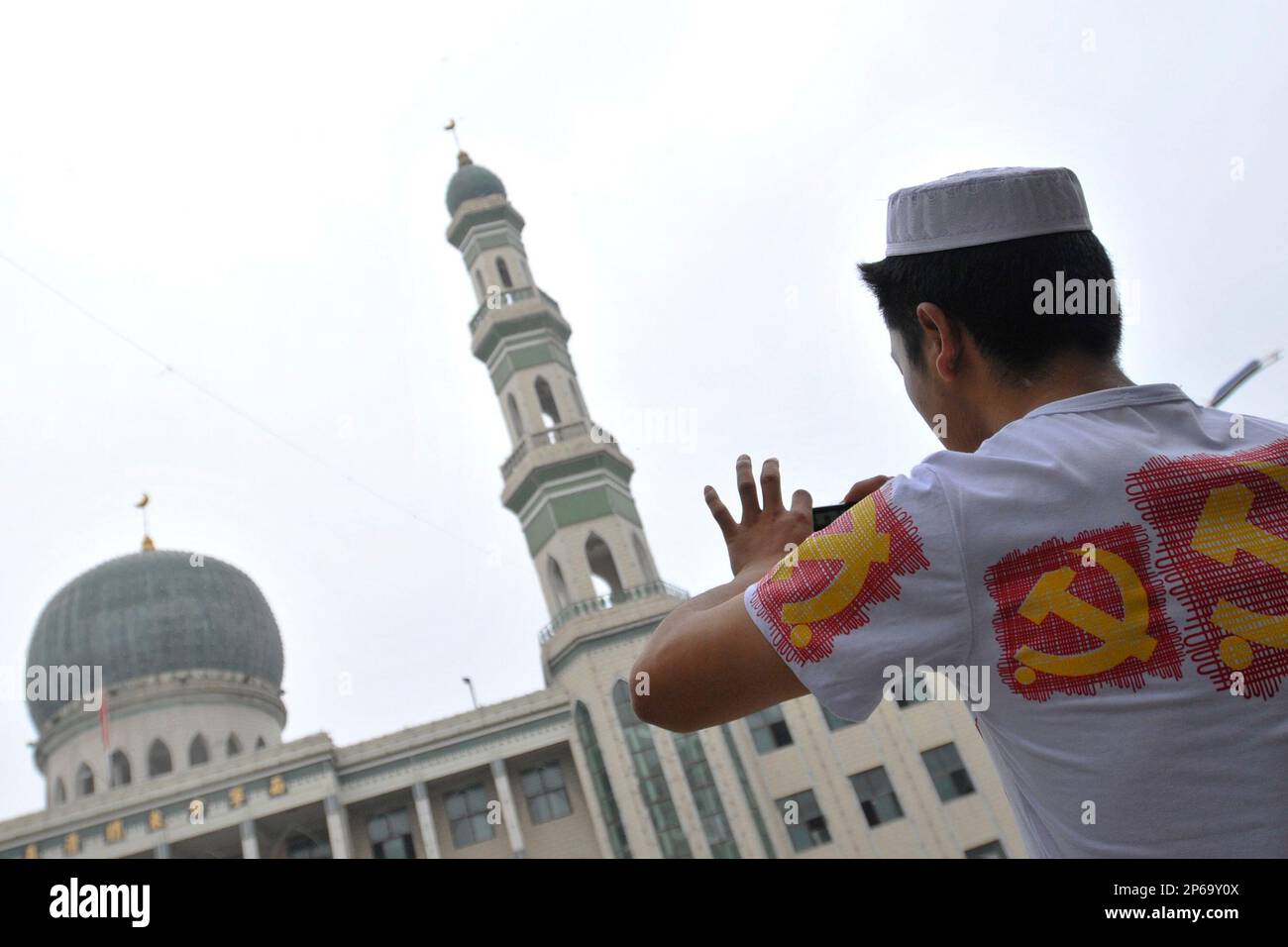 A Muslim wearing a T-shirt showing the hammer and sickle symbols of ...
