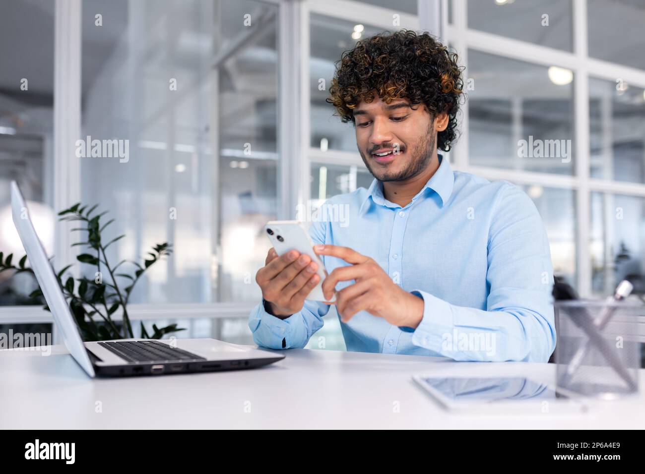 Young indian programmer inside modern office sitting at workplace, man ...