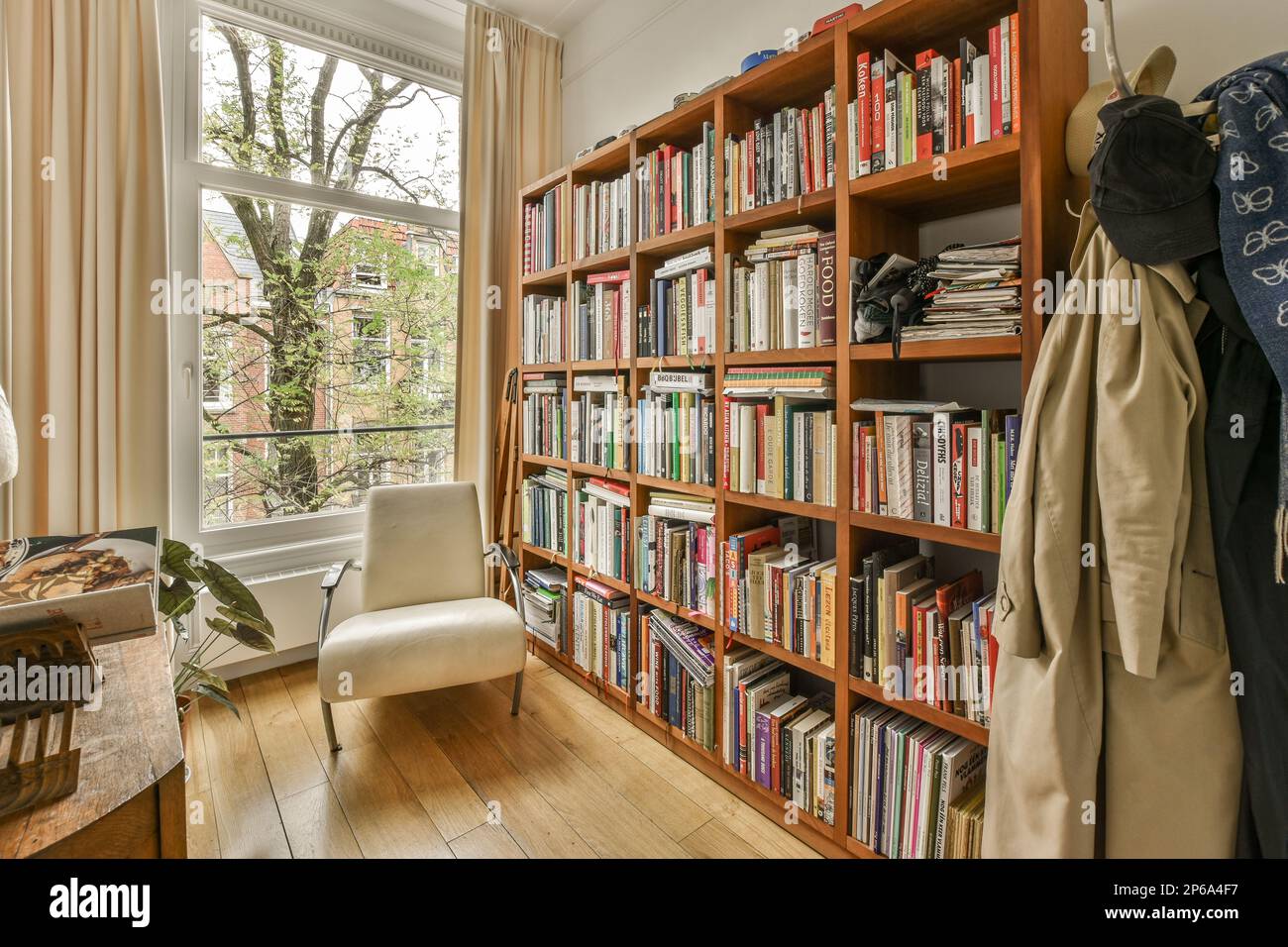 a living room with books on the shelves and a chair in front of a ...