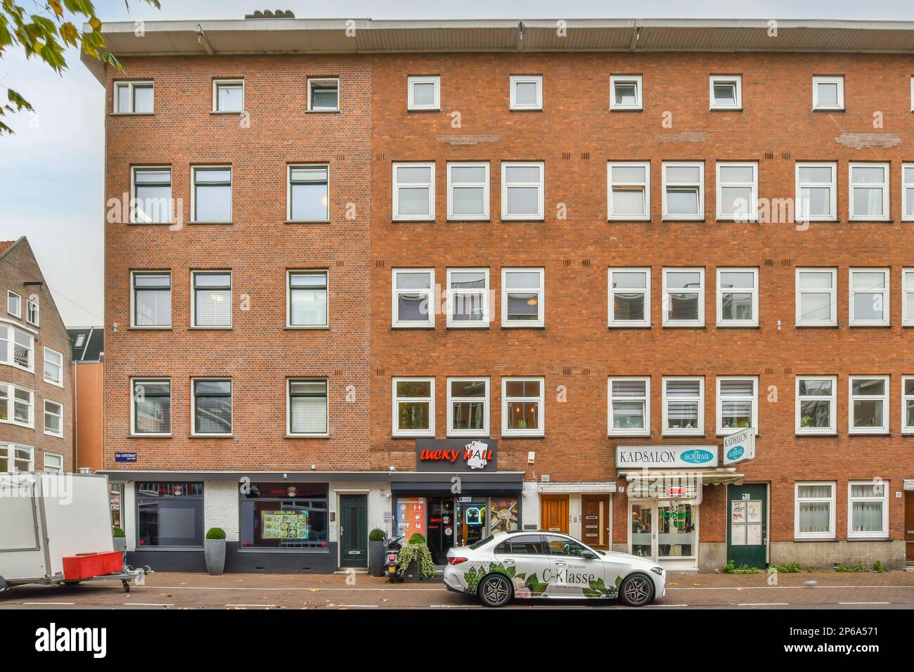 an apartment building with cars parked on the street next to it and ...