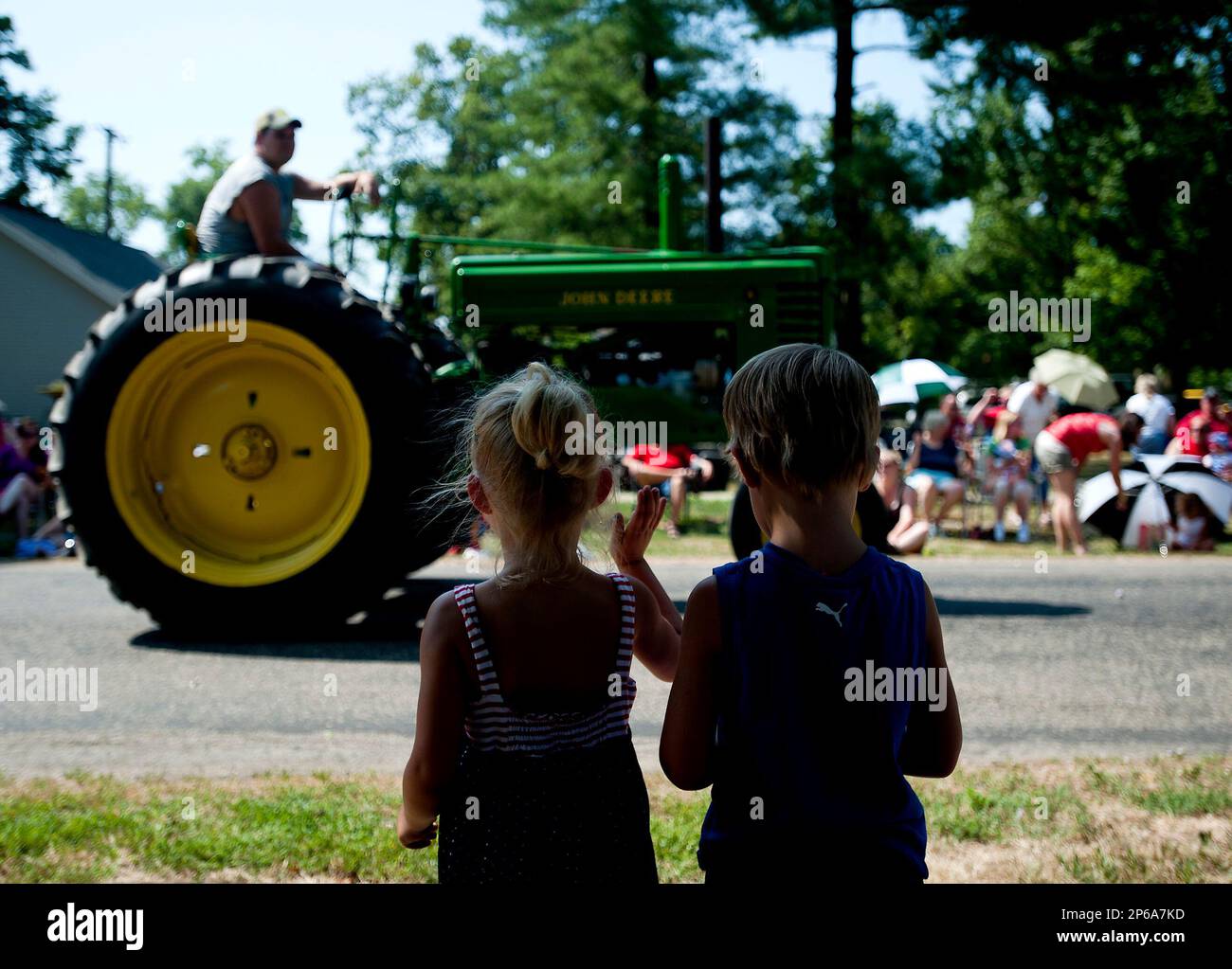 Cousins Lilly Ambler, 4, left, and Landen Boulis, 5, wave at a passing ...