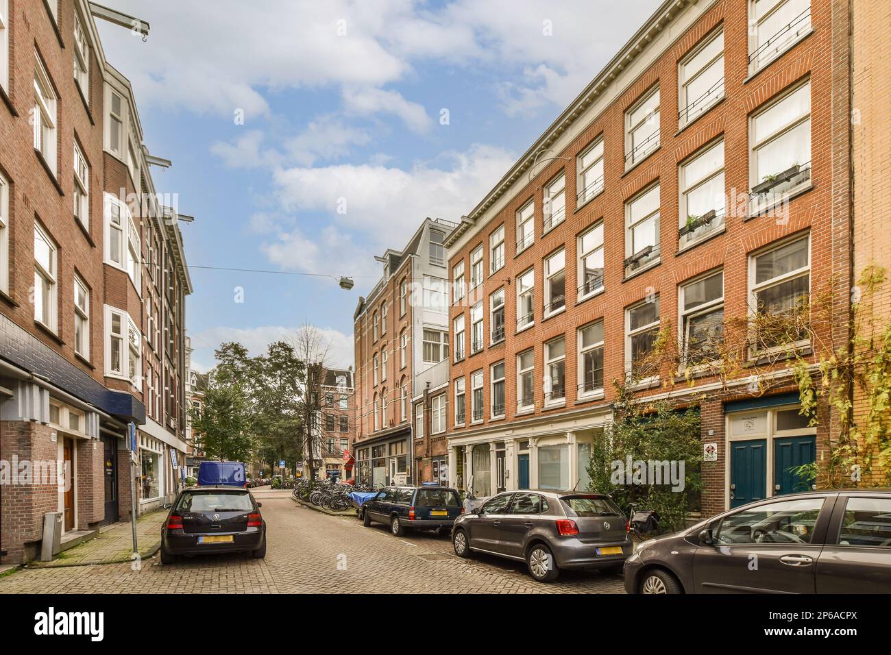 a street with cars parked on the side and buildings in the back ground ...