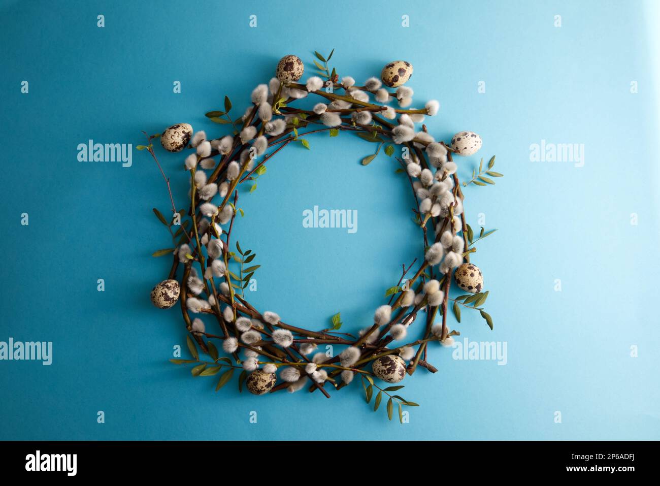 Spring willow wreath decorated with easter eggs and quail eggs on a ...