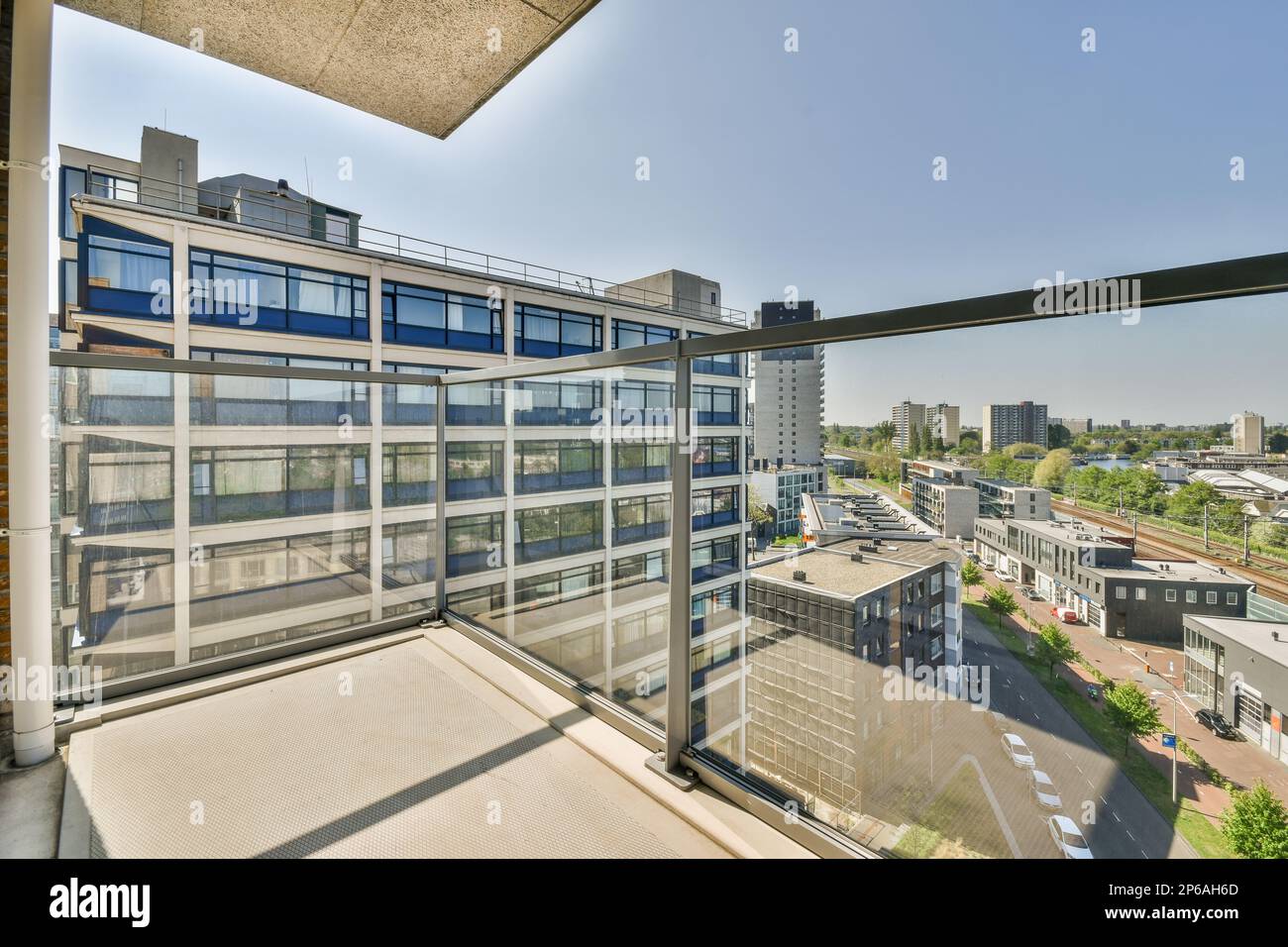 a balcony with some buildings in the background and blue skies overhead ...