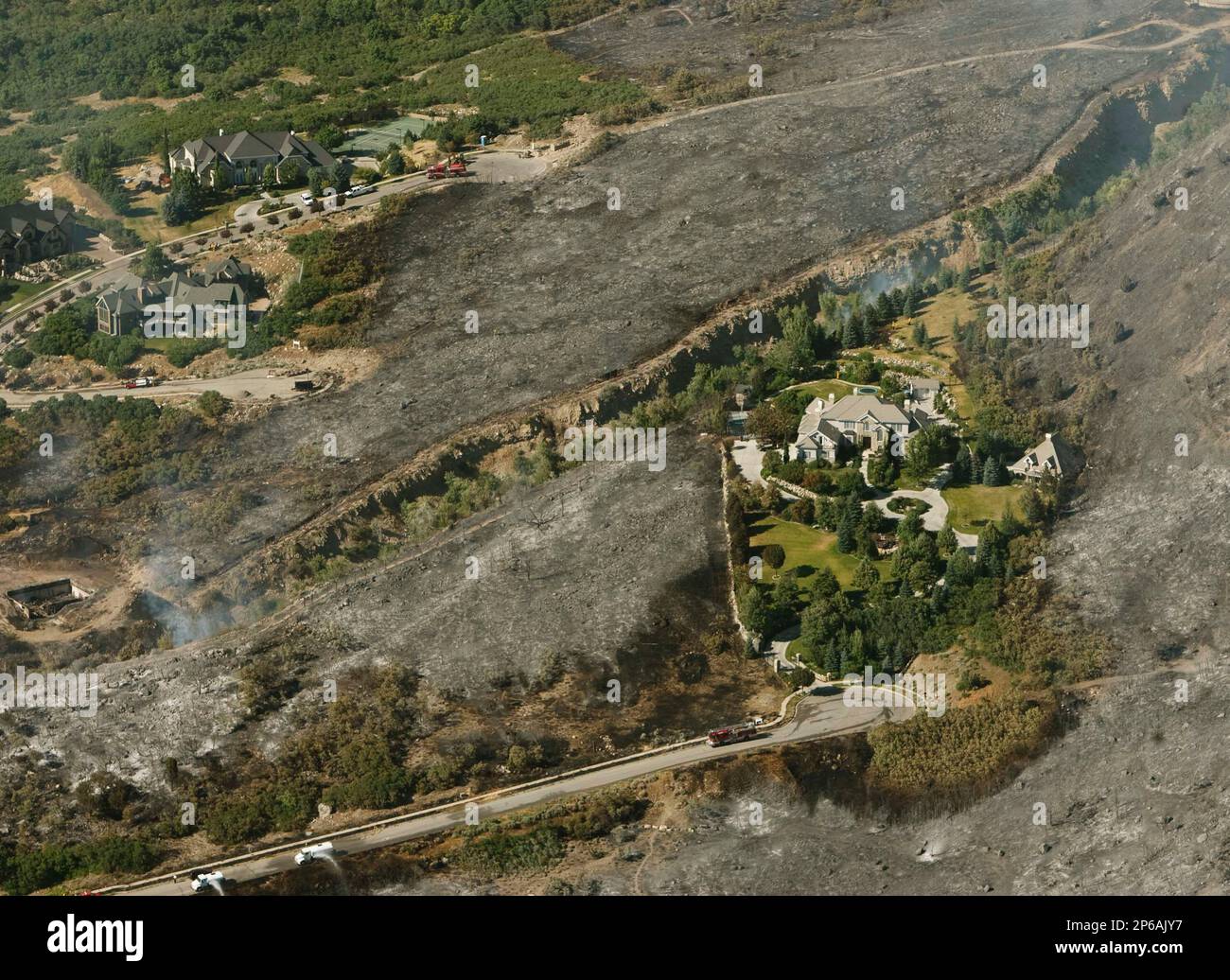A home is surrounded by scorched land around in Lambert Park Tuesday ...