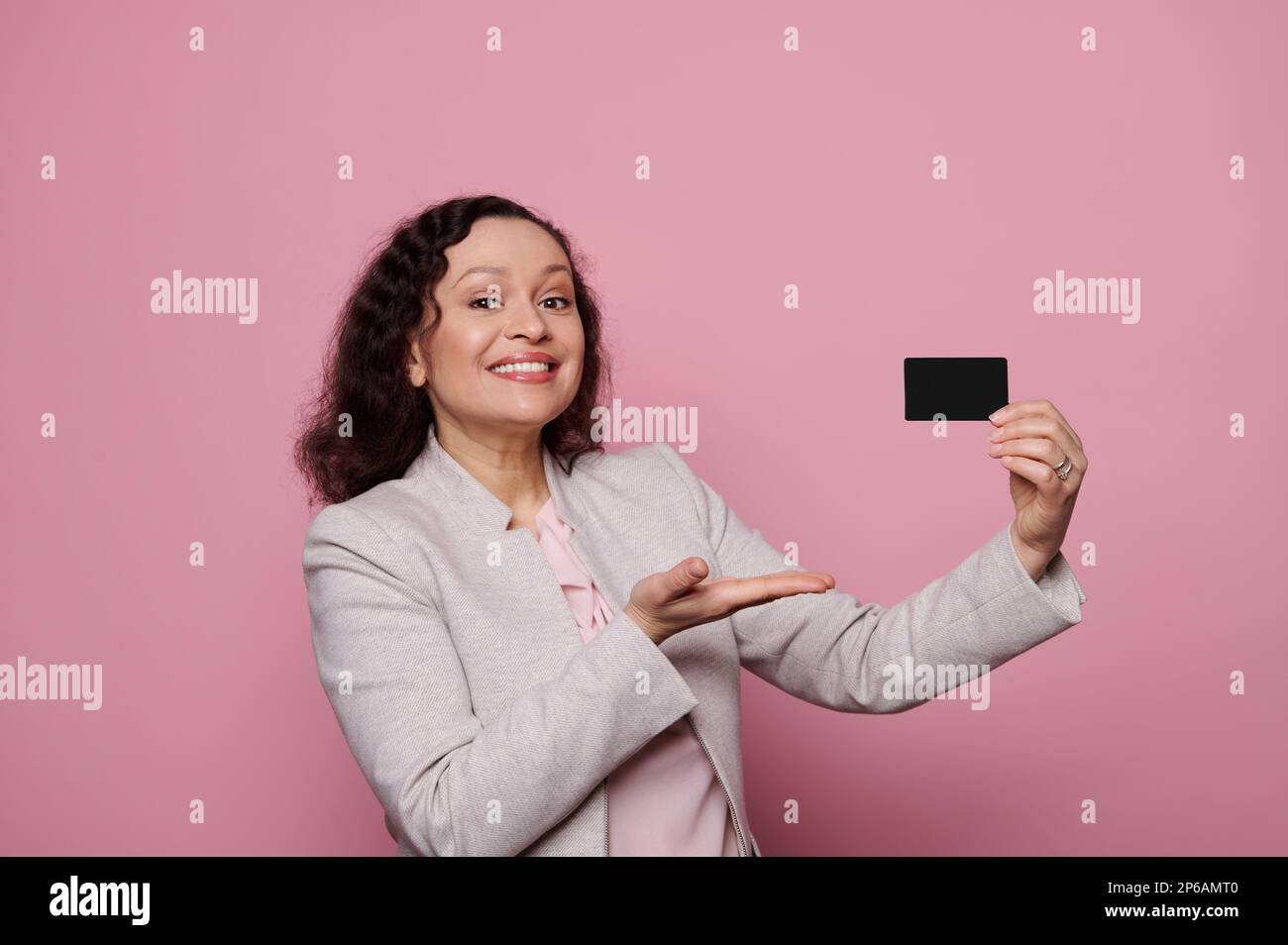 Pleasant woman, bank manager shows black plastic credit card, smiles ...