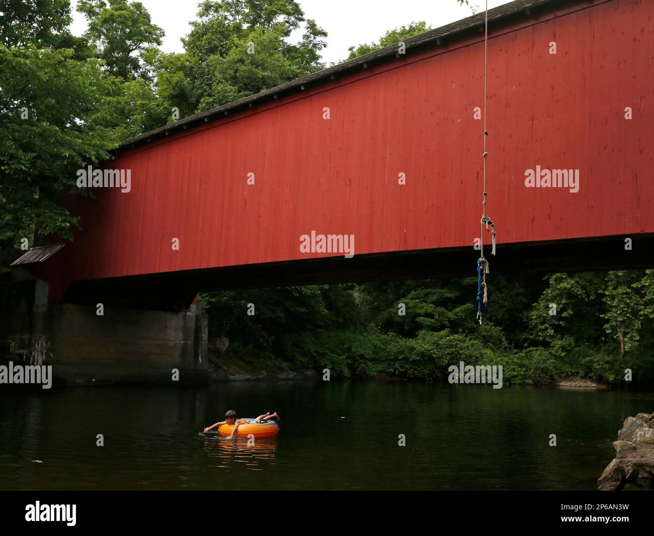 A boy floats on an inner tube on the Batten Kill under the Eagleville Covered Bridge in Jackson ...