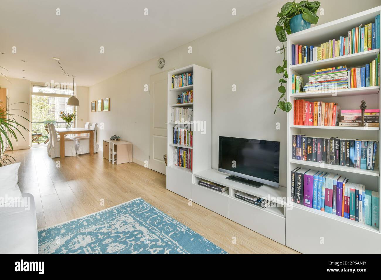 a living room with some books on the shelves and a tv in the corner, as ...