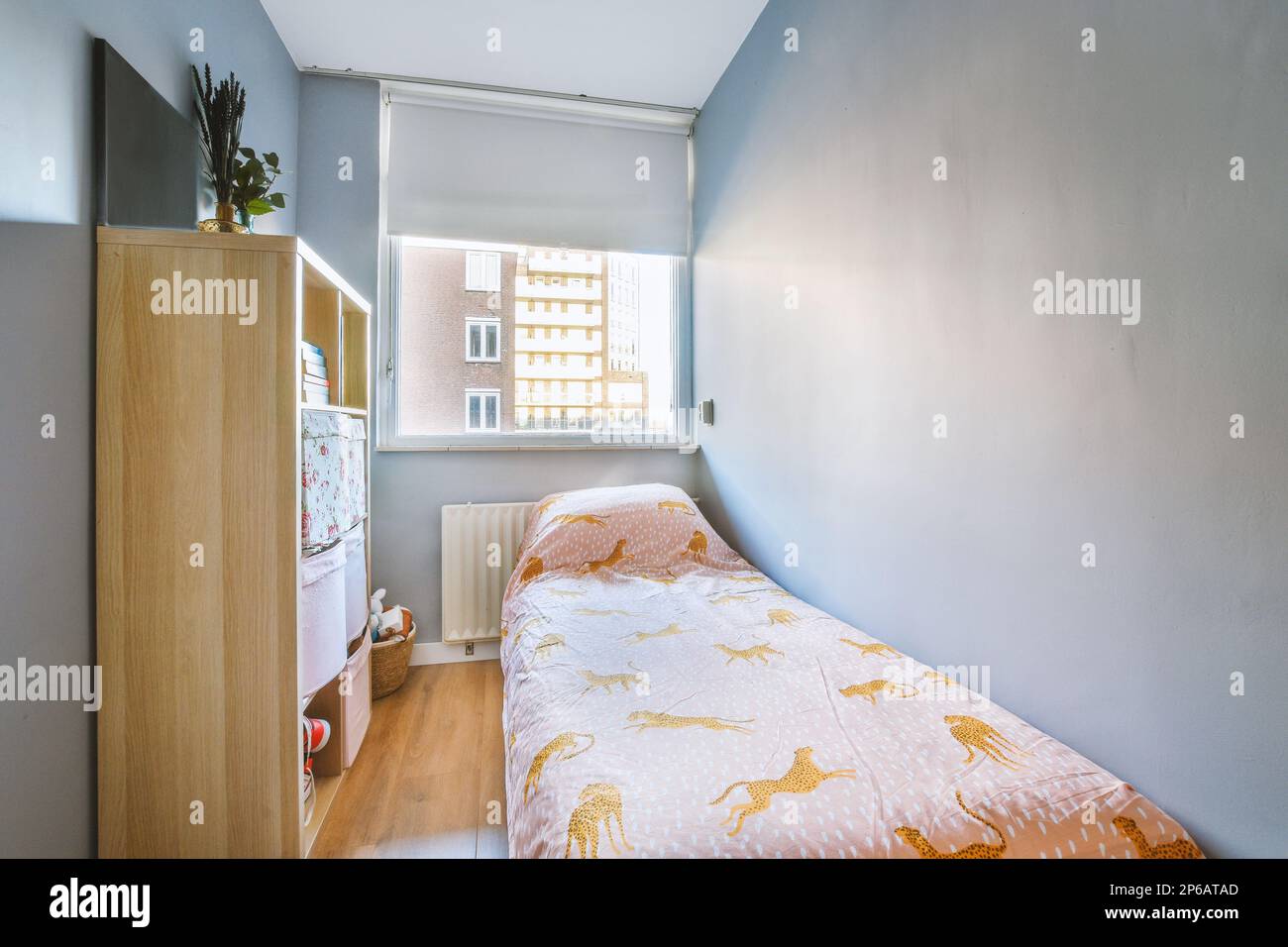 a child's room with a bed, dresser and television set in the corner ...