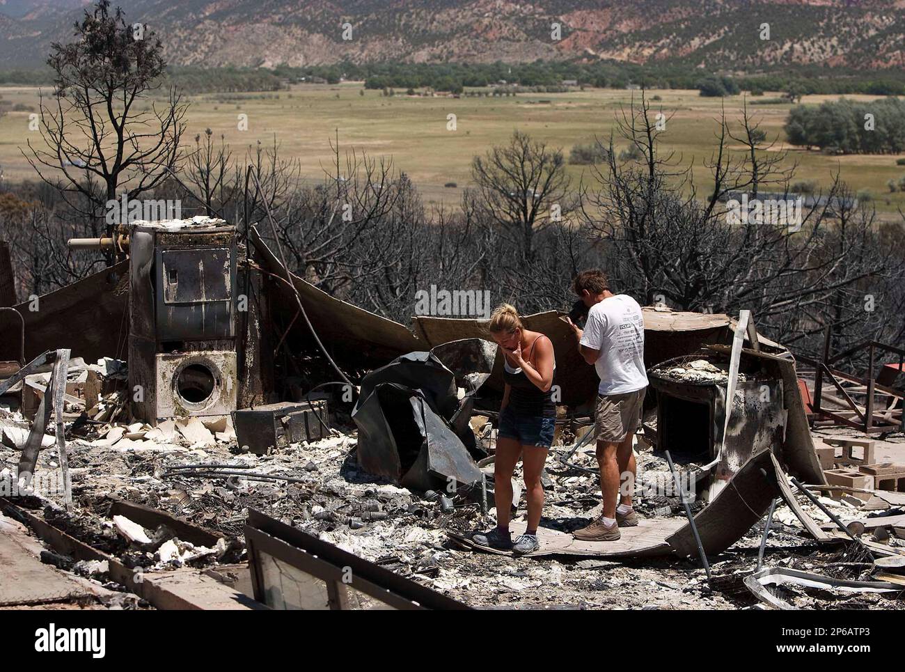 Amy Beattie and her father Bruce Beattie sift through the soot and ash ...