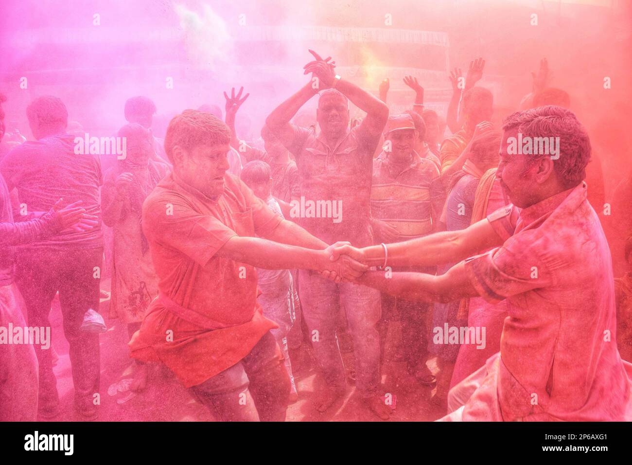 People dance and play with colorful powders during the Holi festival ...