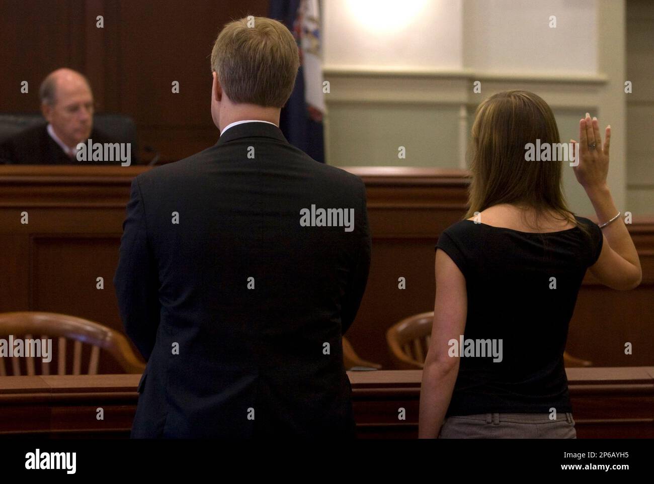 Marina Snyder raises her right hand to take an oath before Judge ...