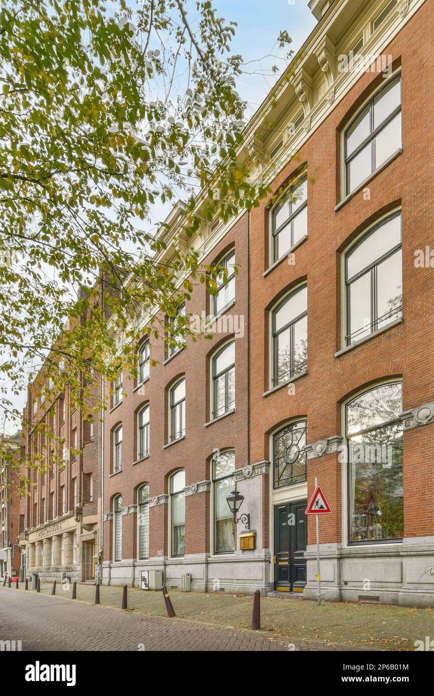 a brick building in the middle of a street with trees on both sides ...