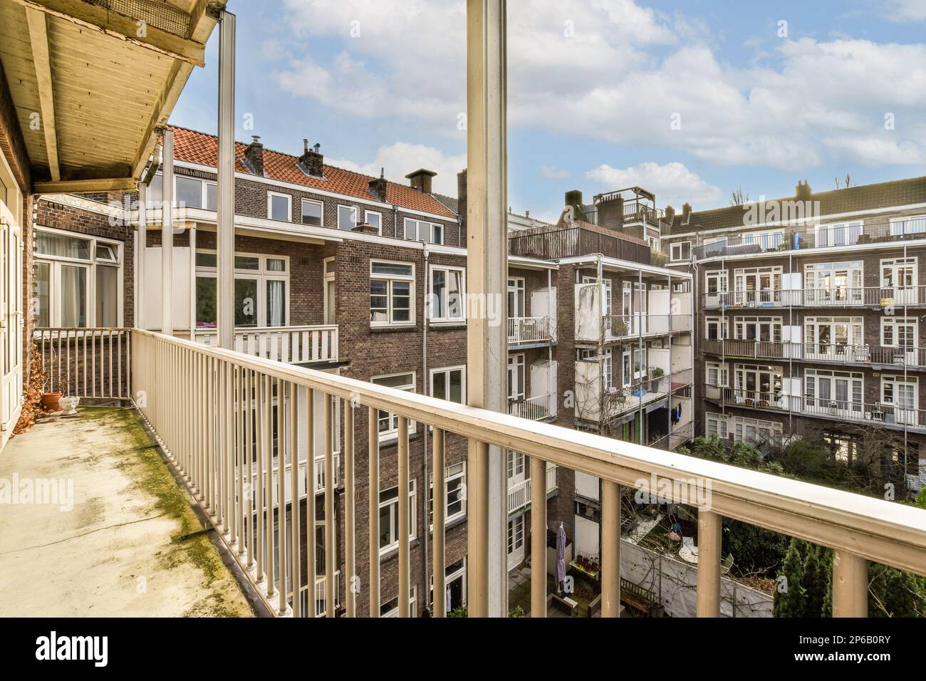a balcony with some houses in the background and a blue sky filled with ...