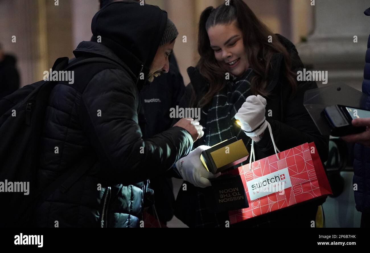 Customers look at their new MoonSwatch during the launch at the Swatch ...