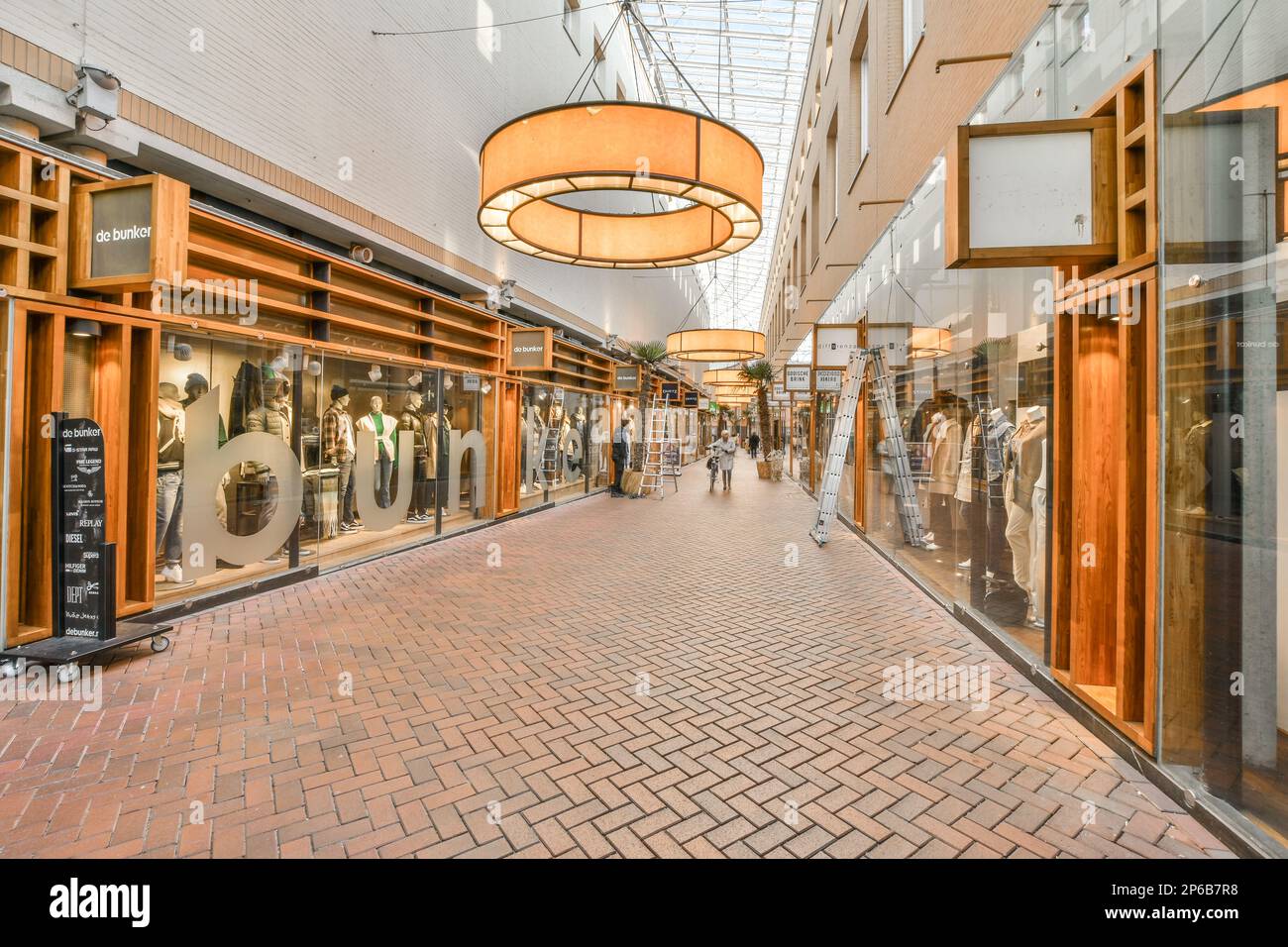 the inside of a clothing store with people walking by and looking at ...