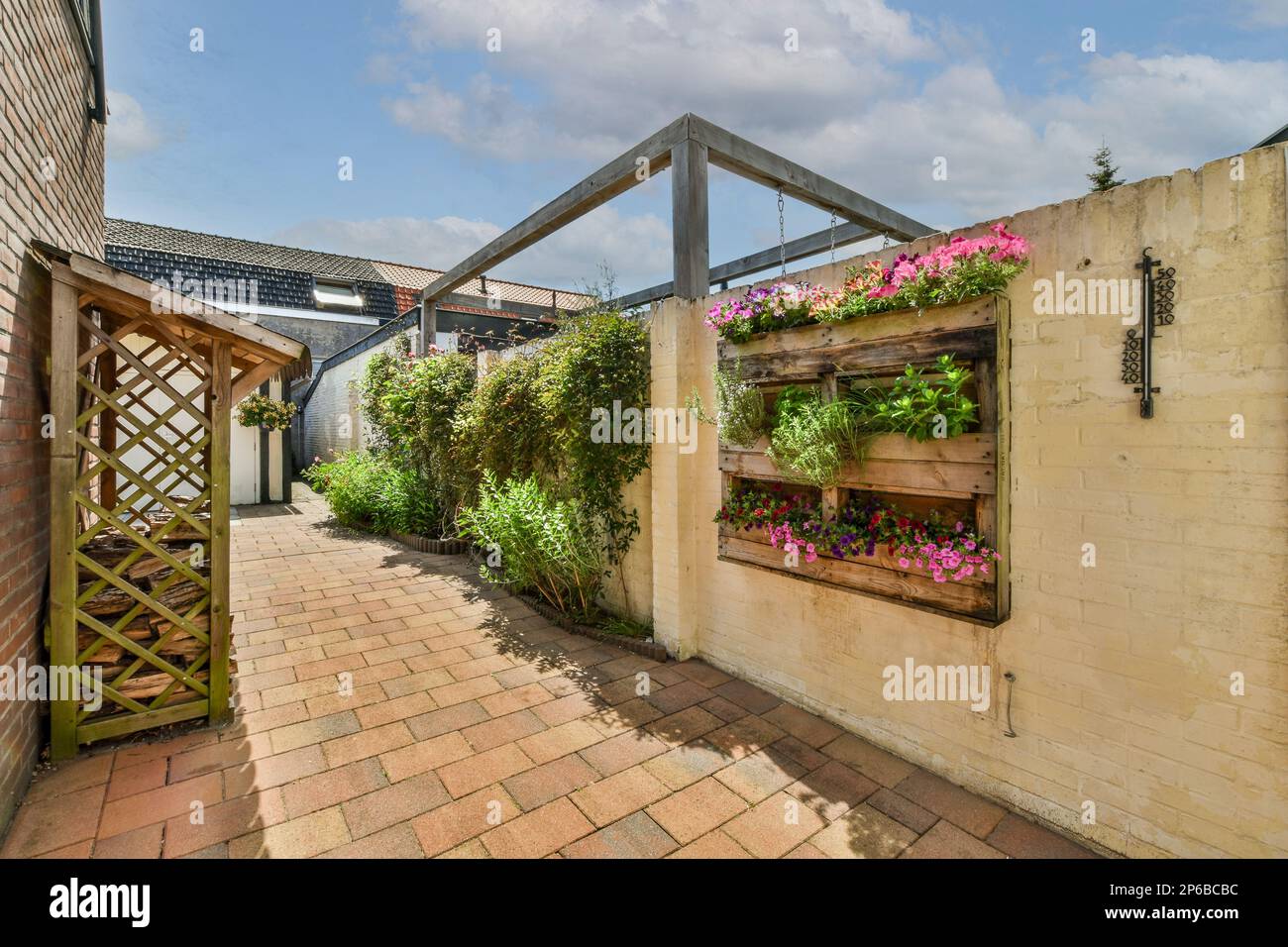 an outside area with flowers on the wall and wooden planters hanging ...