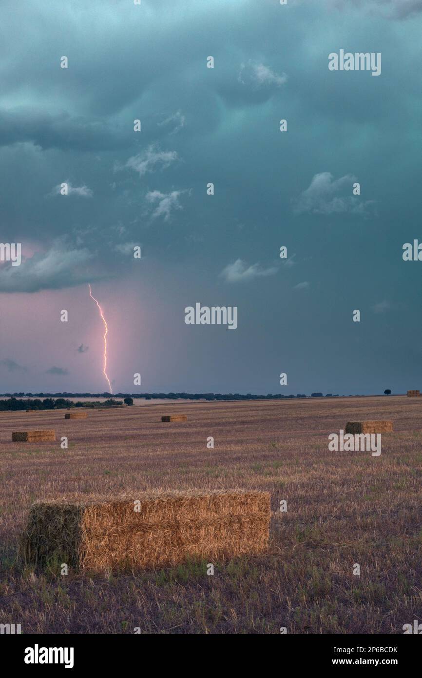 A dramatic sky of thunderstorm clouds, lightning and a warning sign are ...