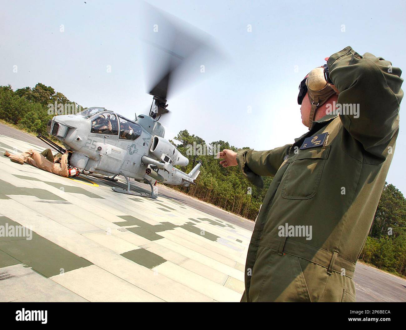 A marine signals as ground support checks on a AHW Cobra that had ...
