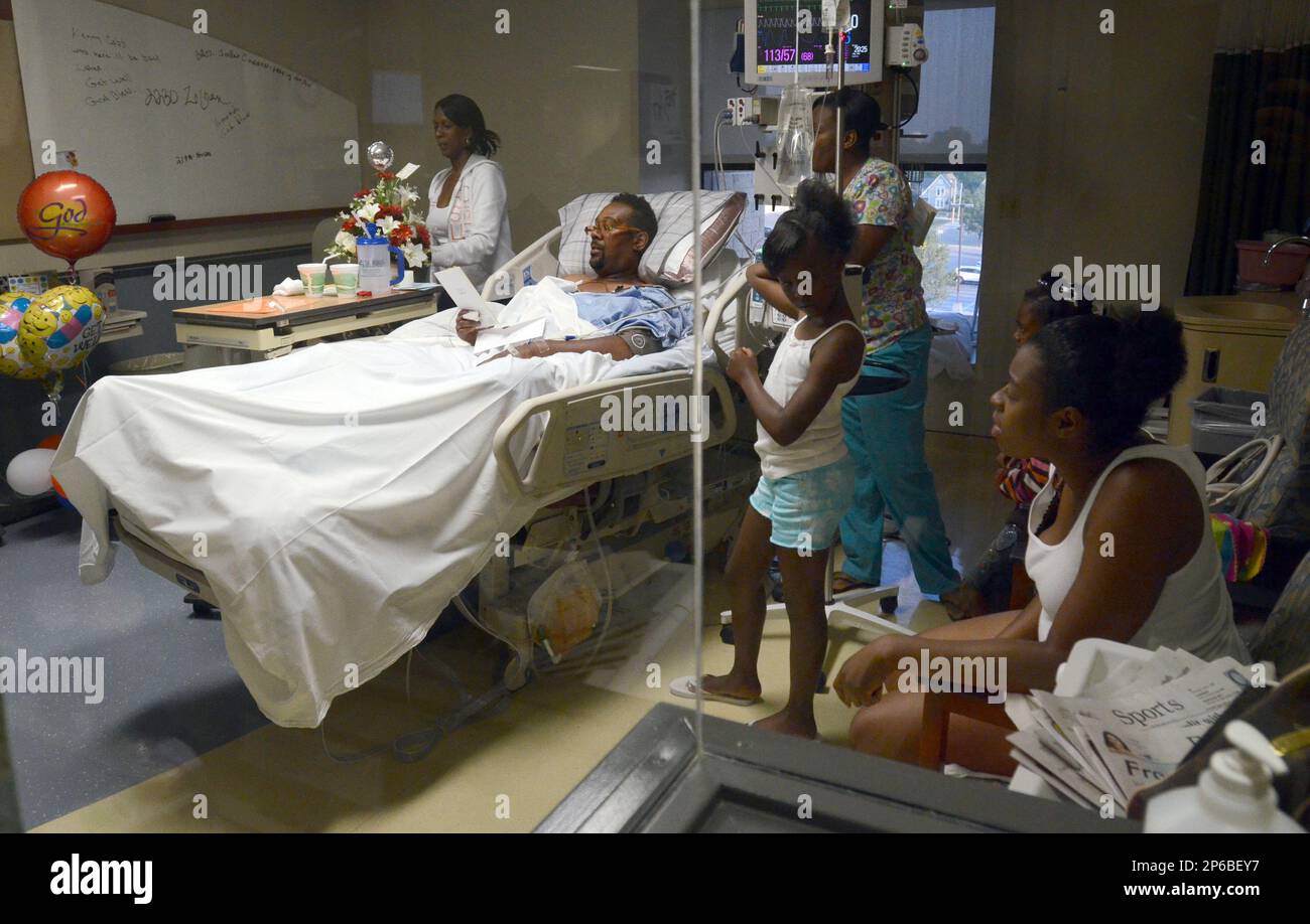 Demetrius Thompson (center) is surrounded by family members in his room ...