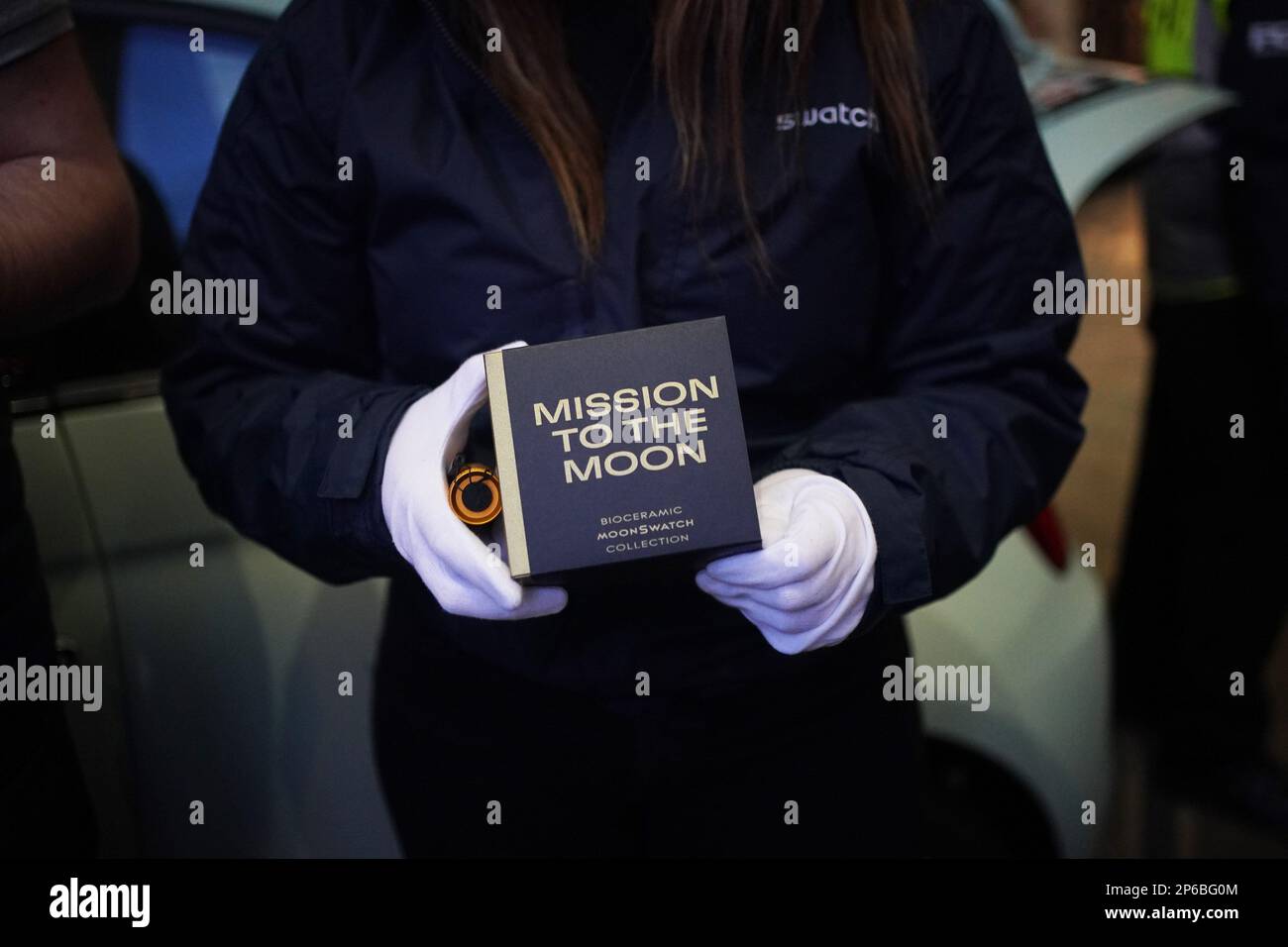 An employee holds the new MoonSwatch during the launch at the Swatch ...
