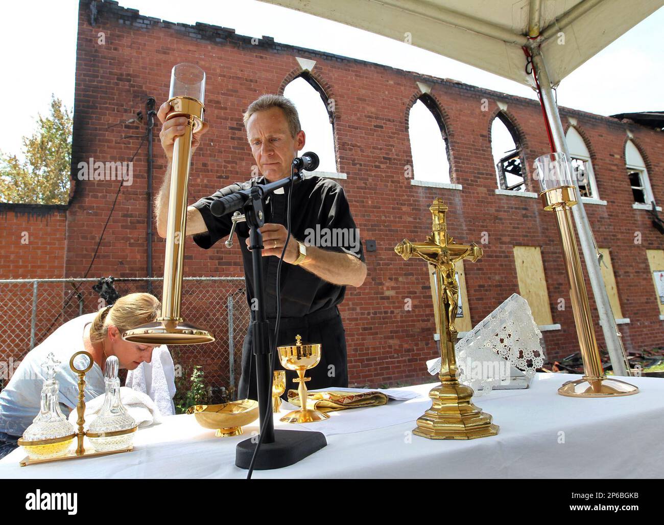 In a Sunday, June 17, 2012 photo, Rev. Andrzej Bako takes down the ...