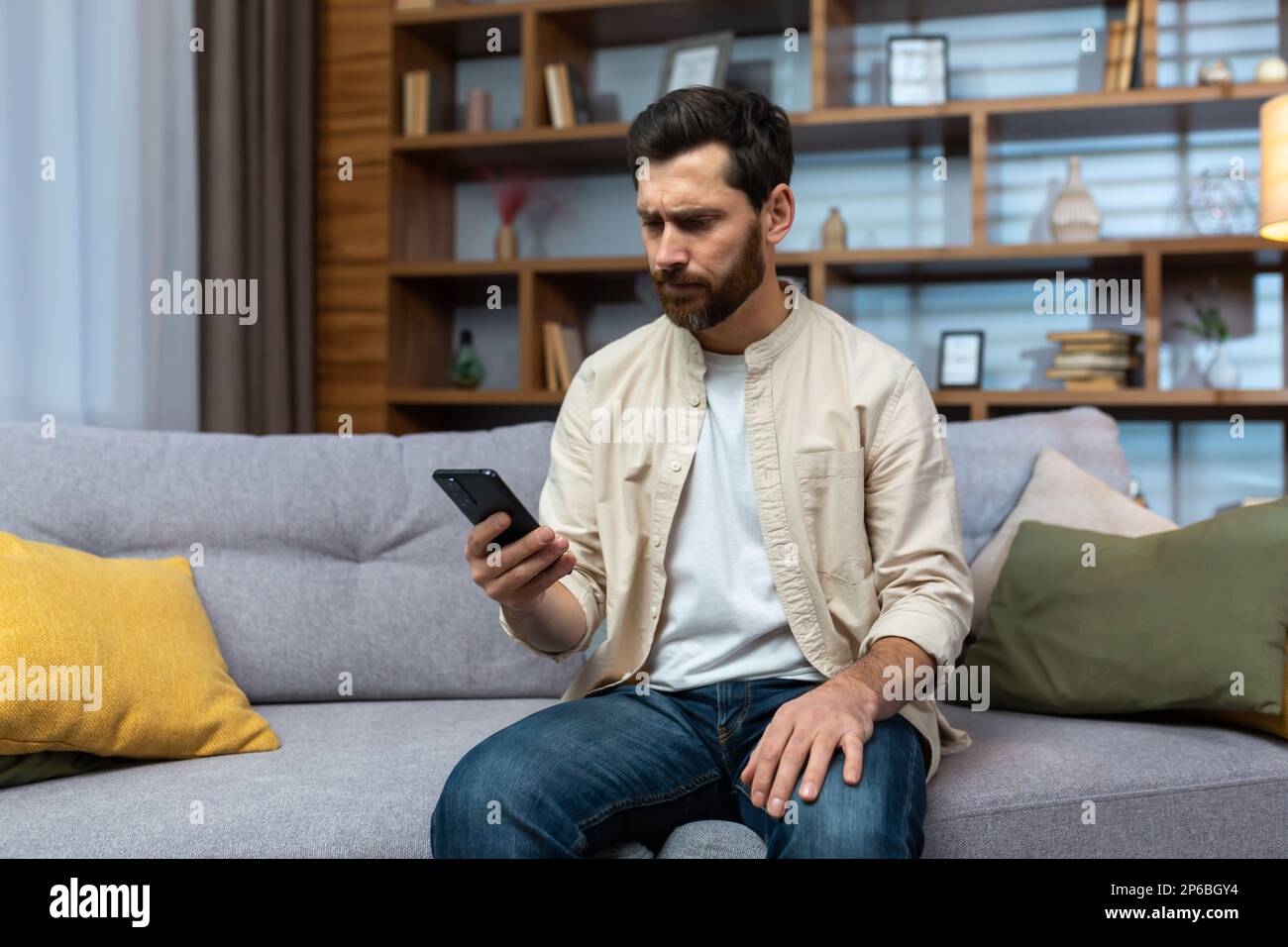 Communication problems. A serious young man in a beige shirt sits on ...