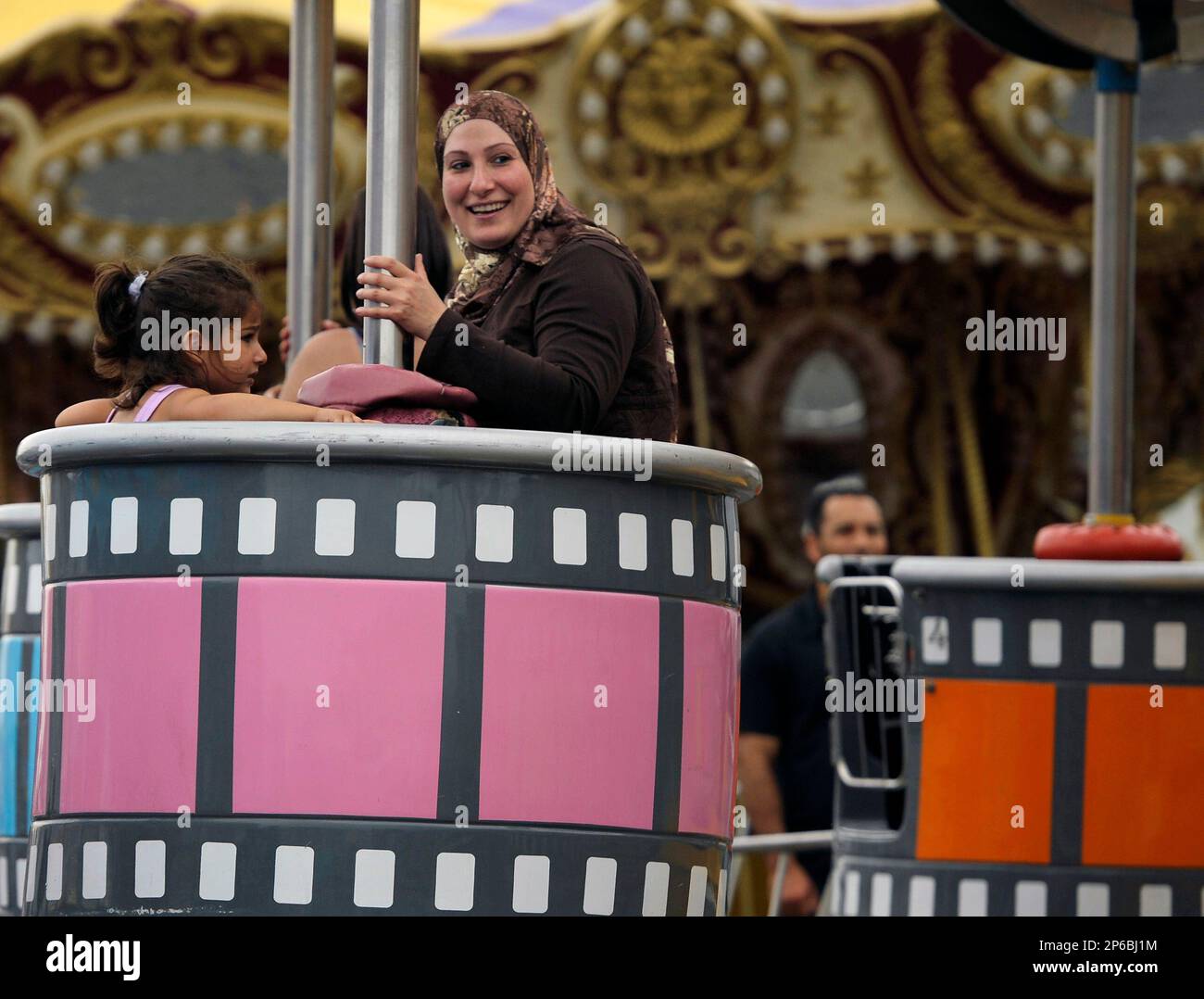 Rayan Hasna and her daughter Onaissi, 4, go on a ride during the Arab ...